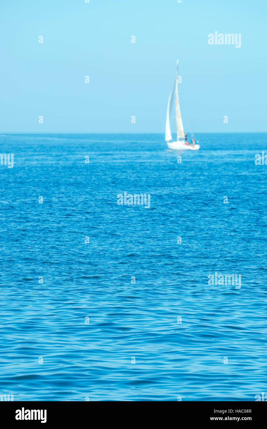 Blue summer seascape with white yacht sailing on horizon in the ...