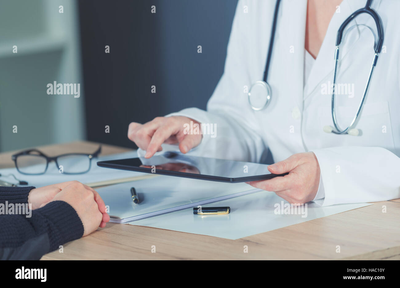 Female doctor presenting medical exam results to patient using digital ...