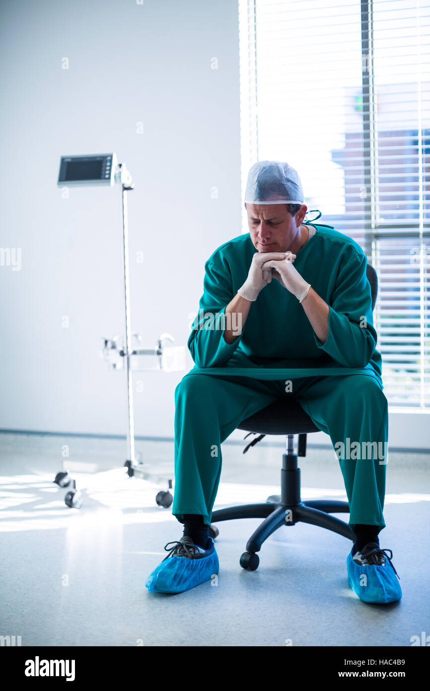 Tensed surgeon sitting on a chair Stock Photo - Alamy Tensed surgeon sitting on a chair Stock Photo - Alamy