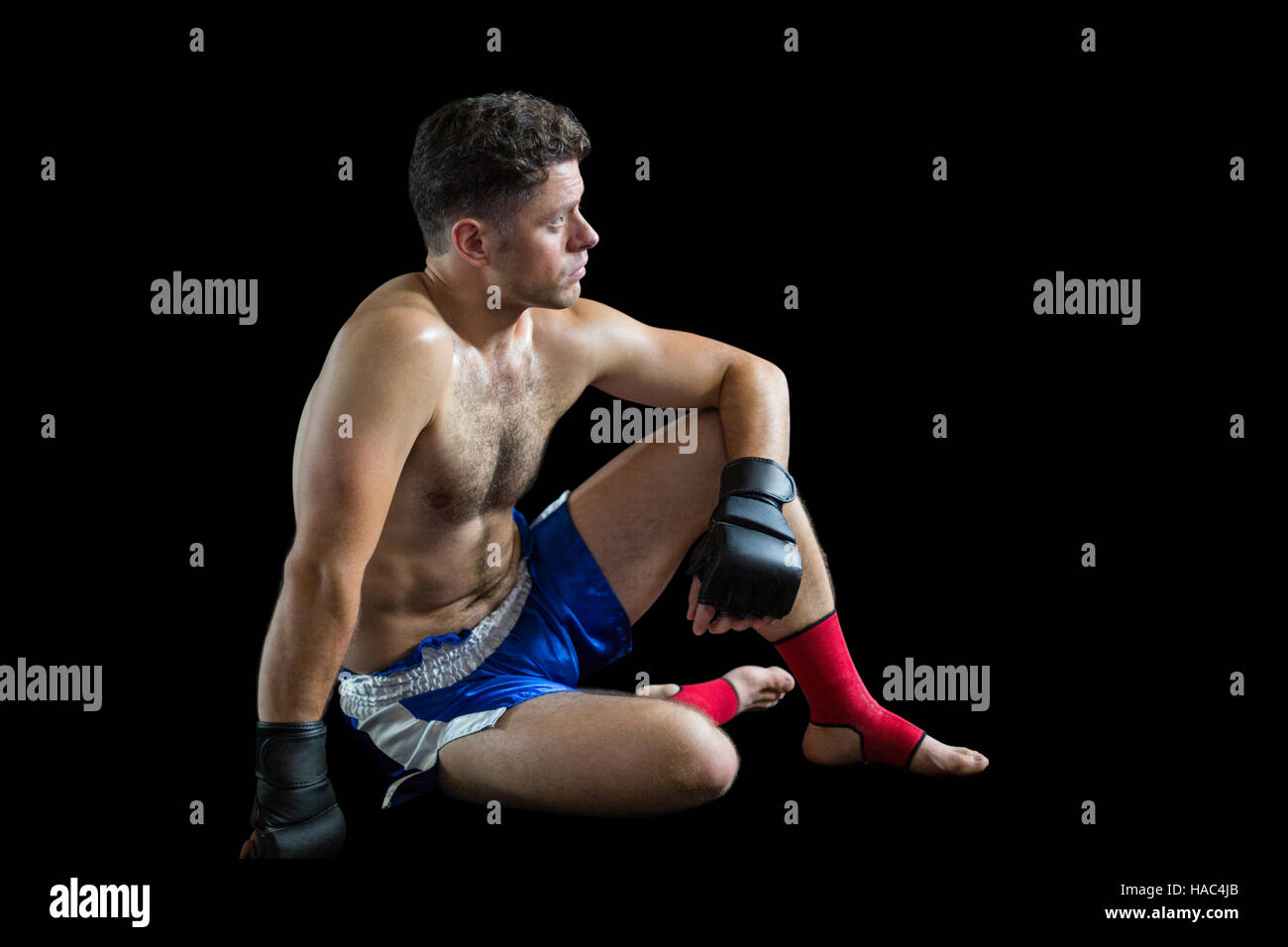 Thoughtful boxer sitting against black background Stock Photo - Alamy