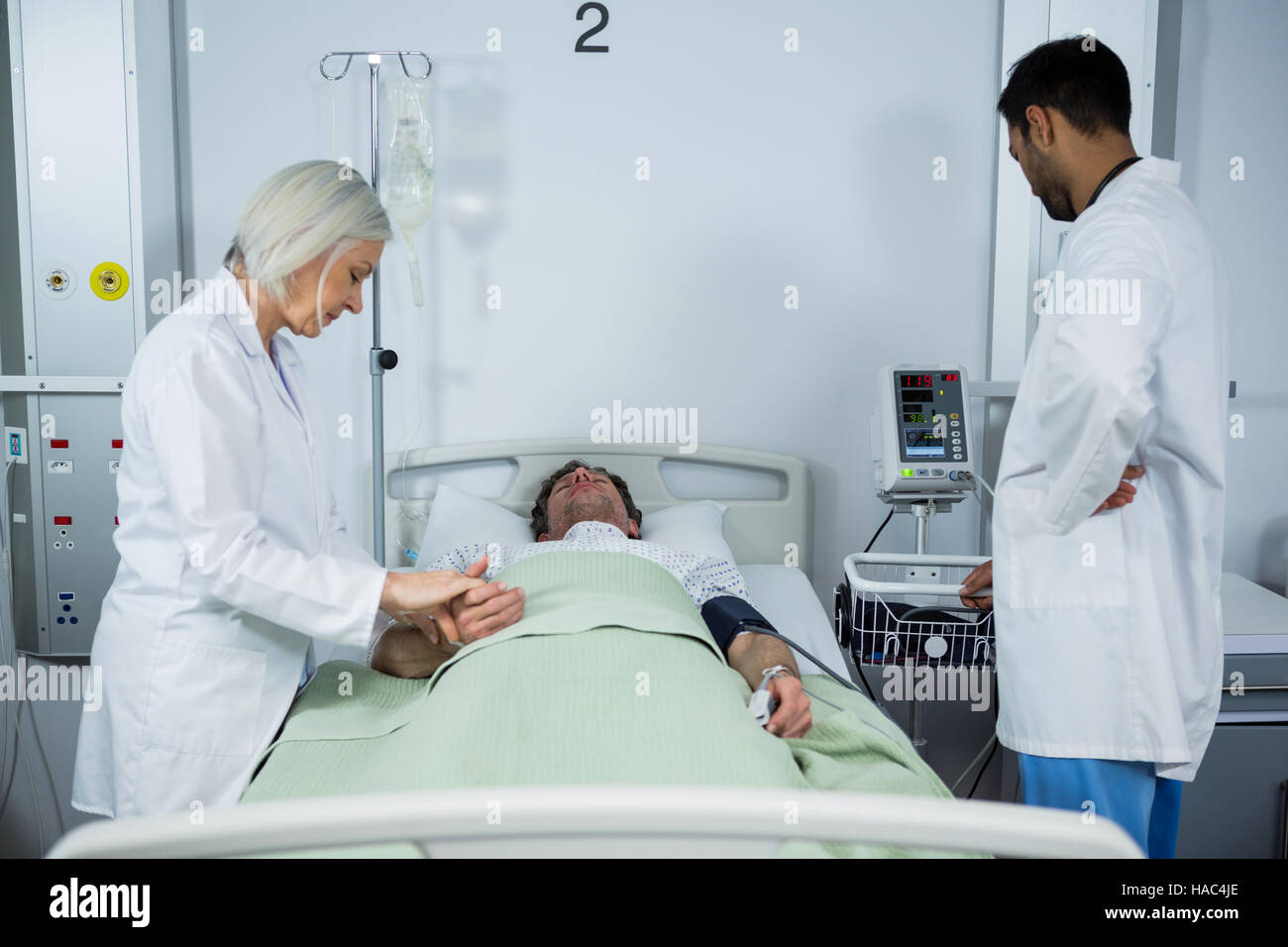 Doctor checking pulse of patient Stock Photo - Alamy