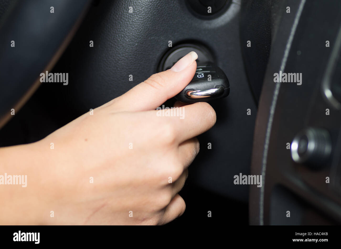 Closeup inside vehicle of hand holding key in ignition, steering wheel ...