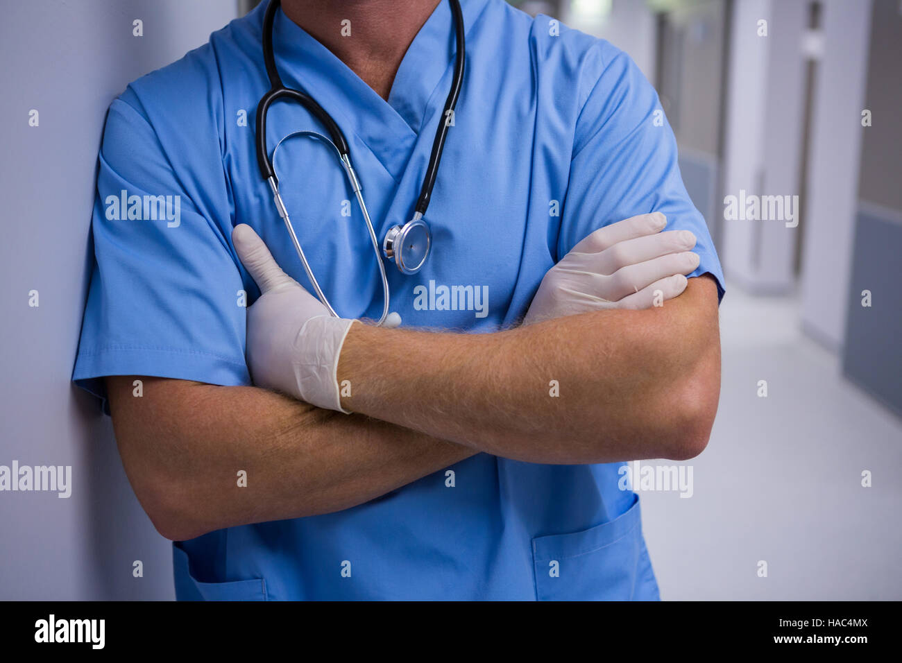 Surgeon standing with arms crossed in corridor at hospital Stock Photo ...