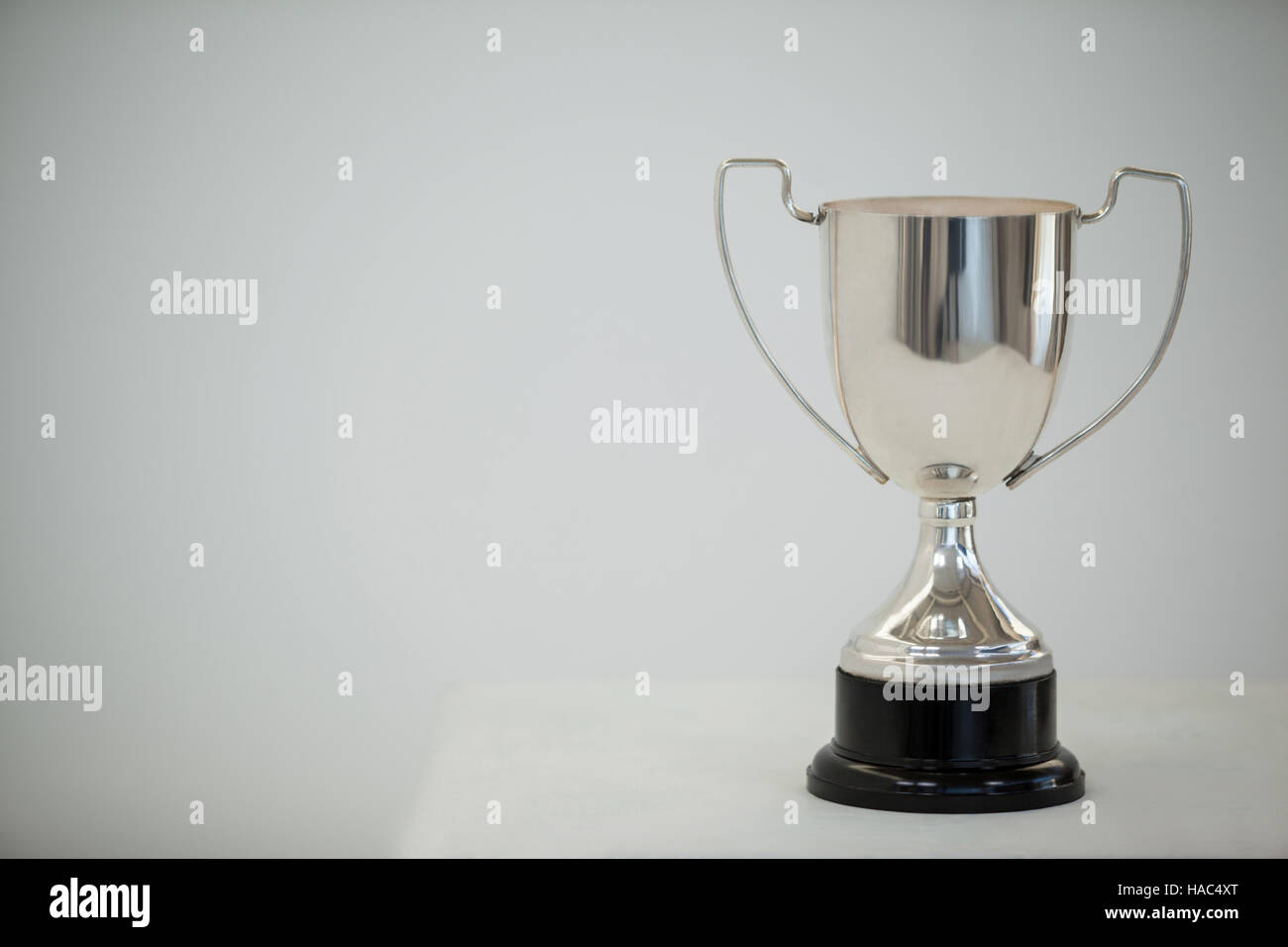 Silver trophy on grey background Stock Photo - Alamy