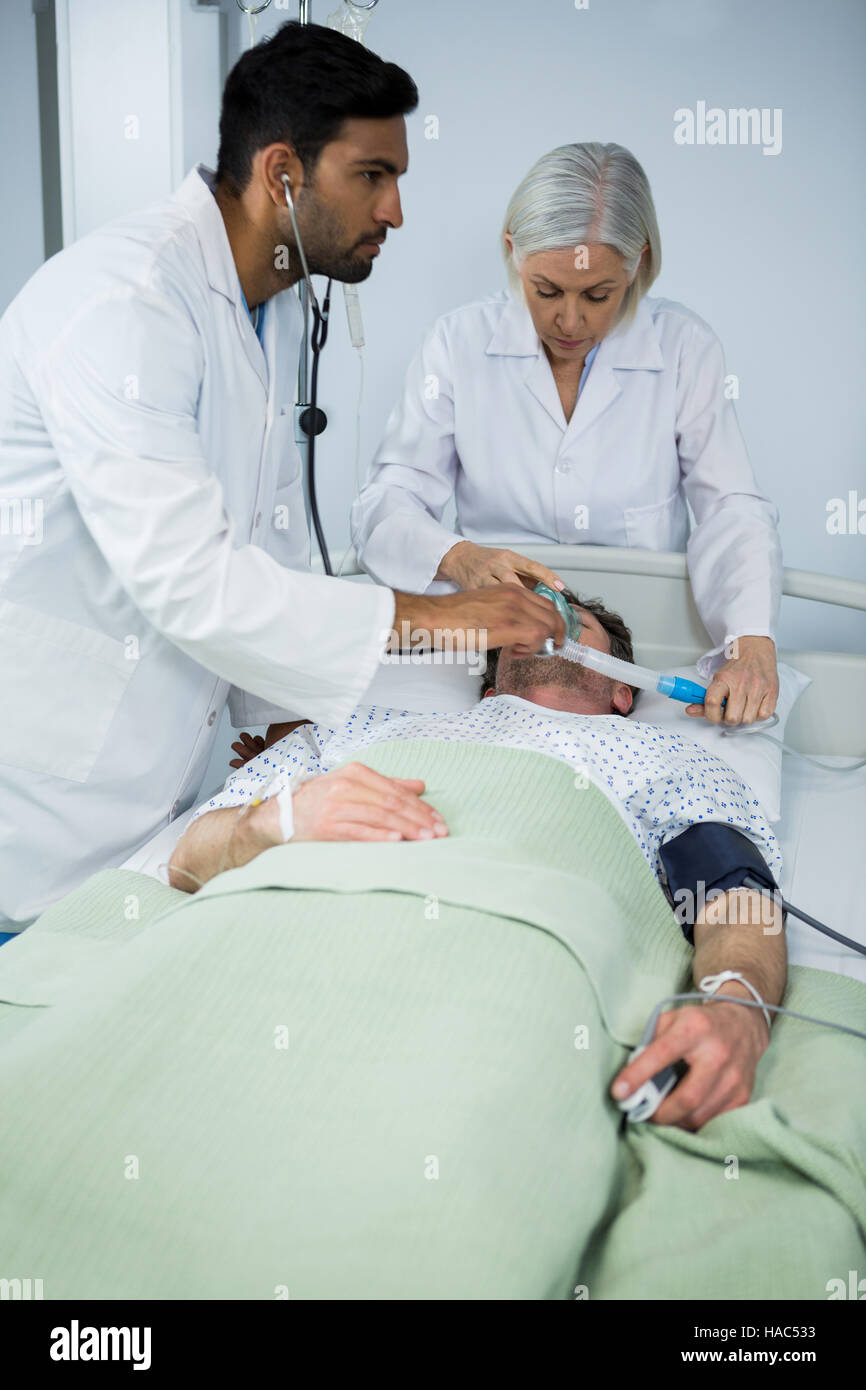 Doctor placing an oxygen mask on the face of a patient Stock Photo - Alamy