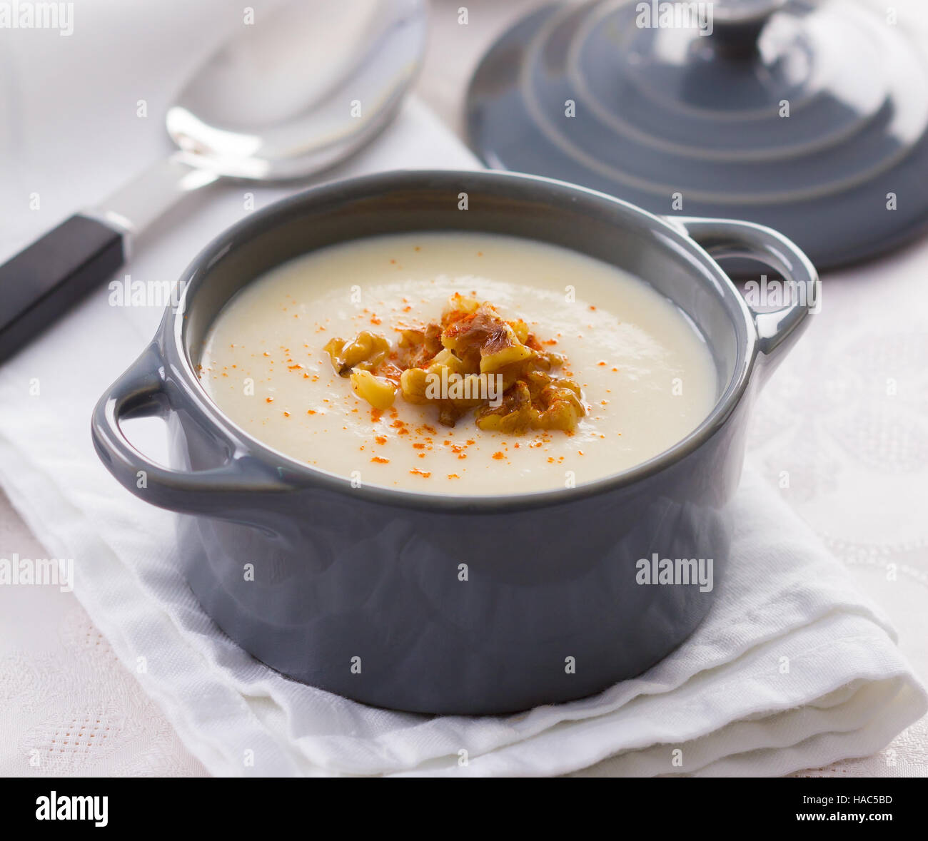 Creamy soup in a small ceramic cooking pot, garnished with walnut Stock ...