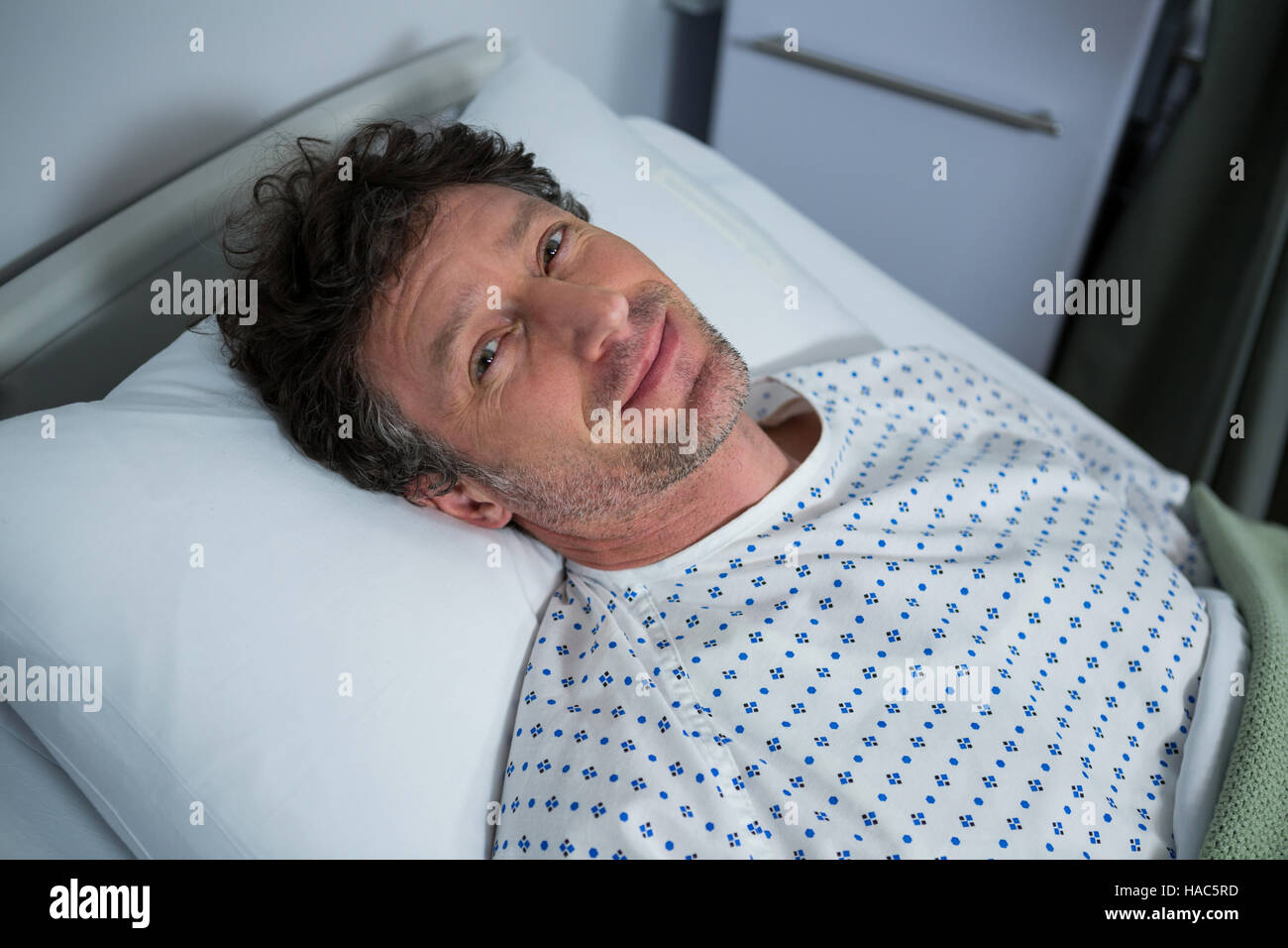 Male patient relaxing on bed in ward Stock Photo - Alamy