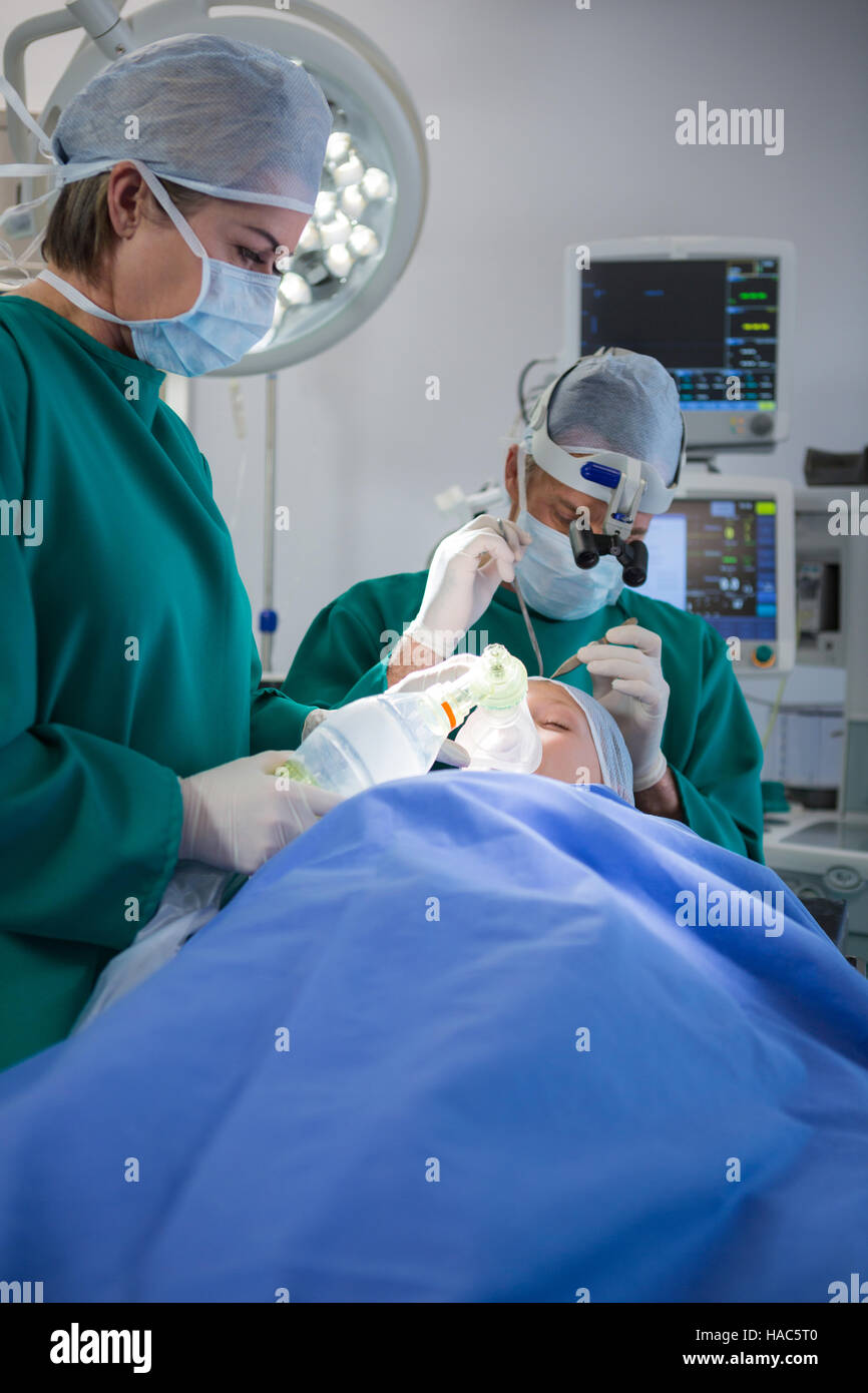 Surgeons operating patient Stock Photo - Alamy