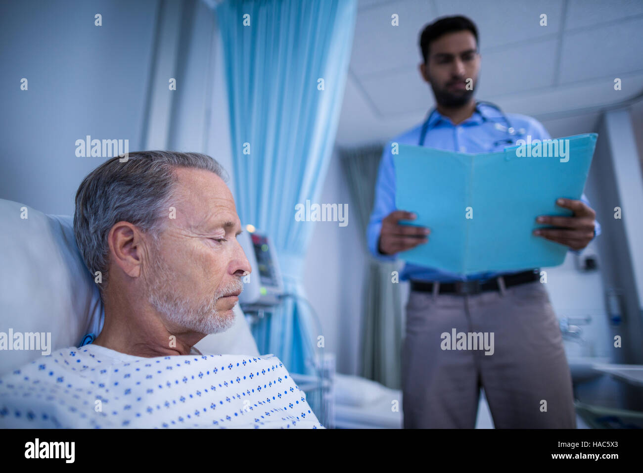 Doctor checking medical report of patient Stock Photo - Alamy
