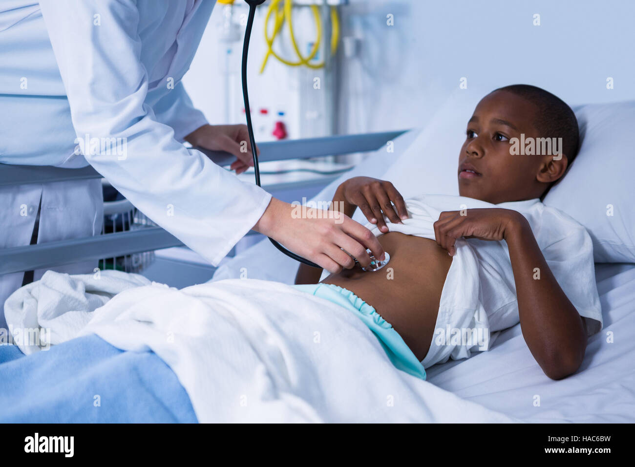 Doctor examining patient with stethoscope in ward Stock Photo - Alamy