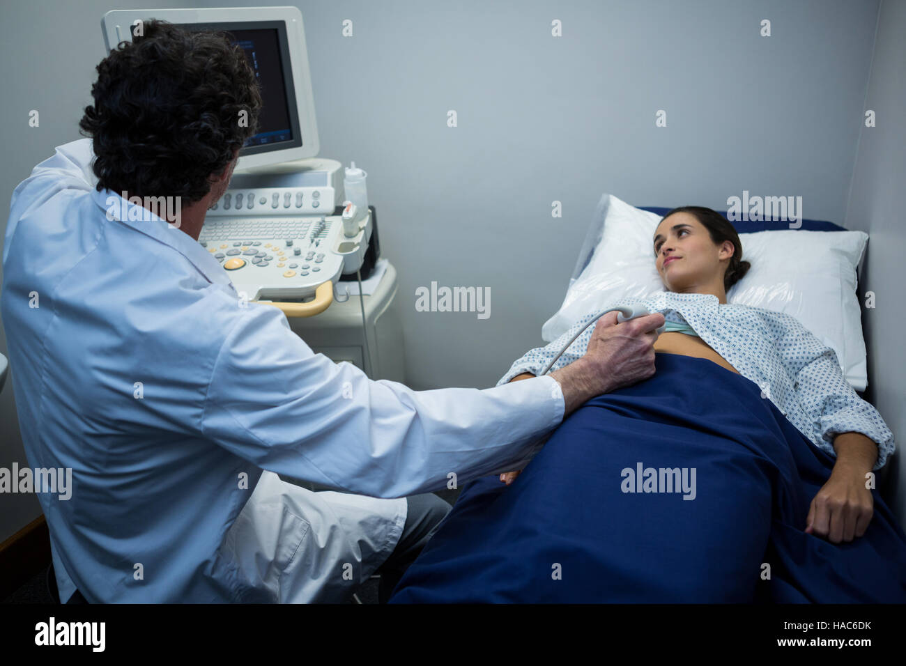 Doctors performing a doppler sonography on patient stomach Stock Photo ...