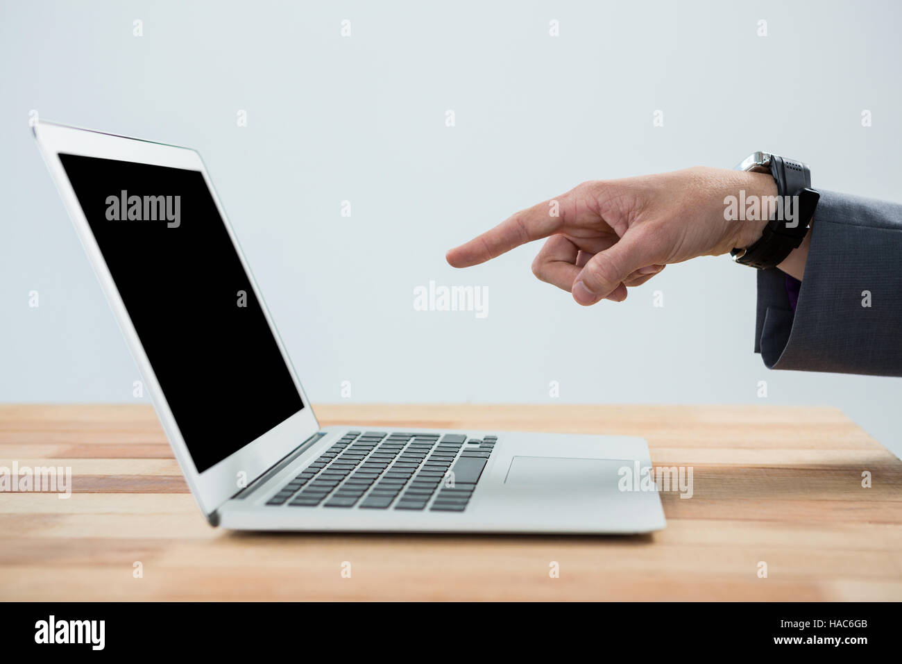 Businessman pointing at laptop Stock Photo - Alamy
