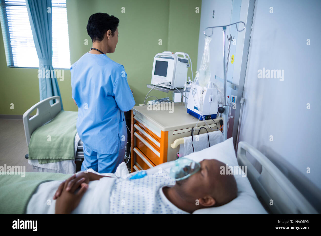 Nurse looking at patient monitoring machine Stock Photo - Alamy