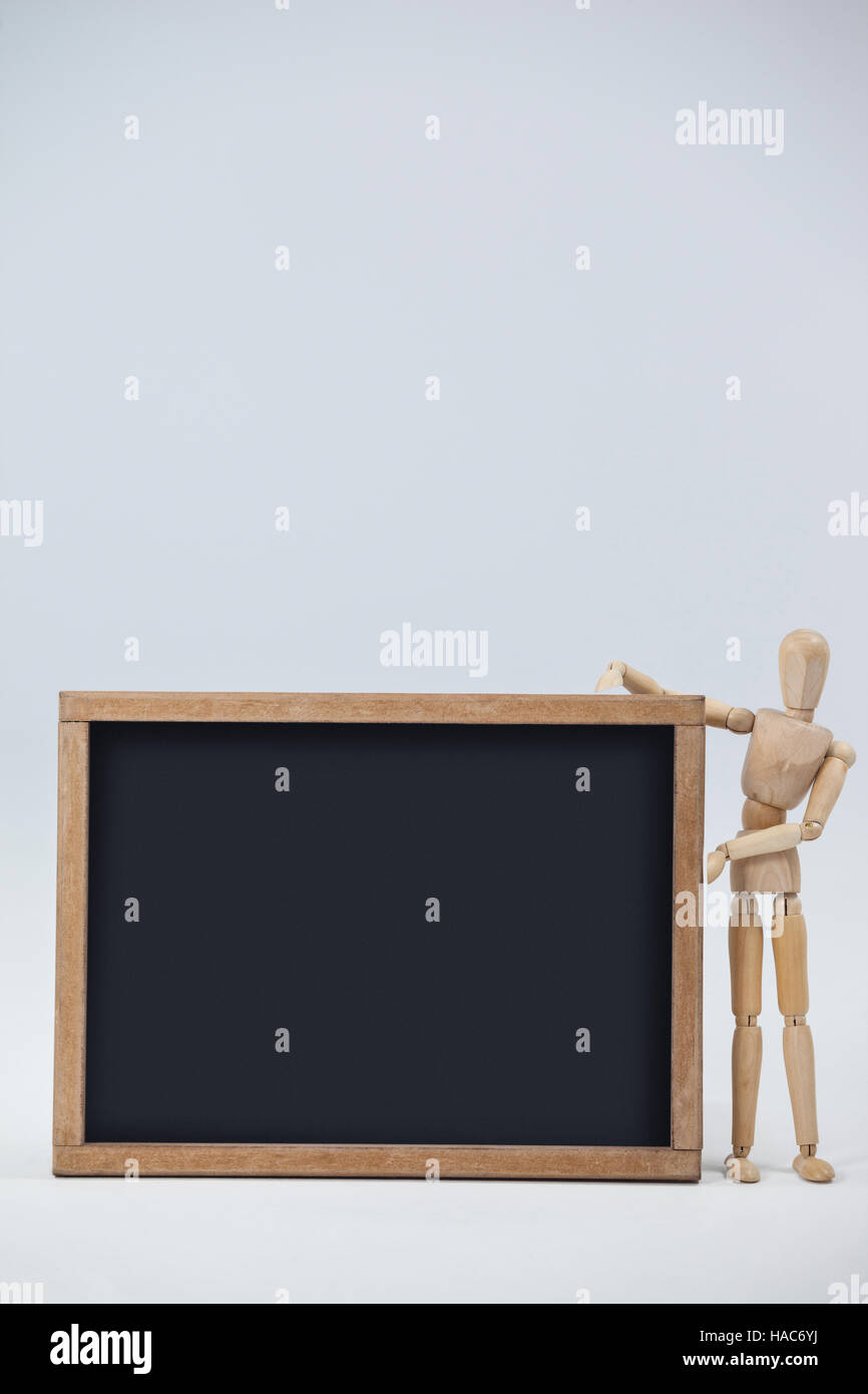 Wooden figurine standing beside a slate board Stock Photo - Alamy