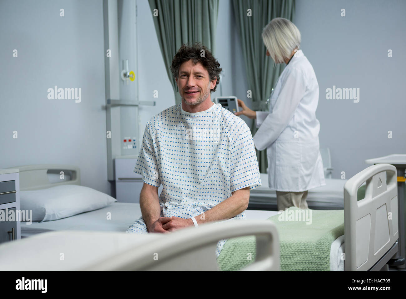 Portrait of patient sitting on bed in ward Stock Photo - Alamy