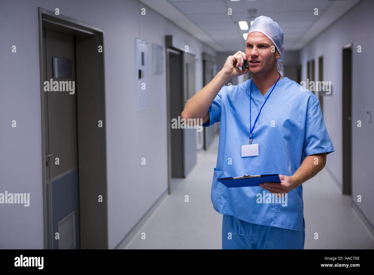 Surgeon standing in corridor and talking on mobile phone Stock Photo ...