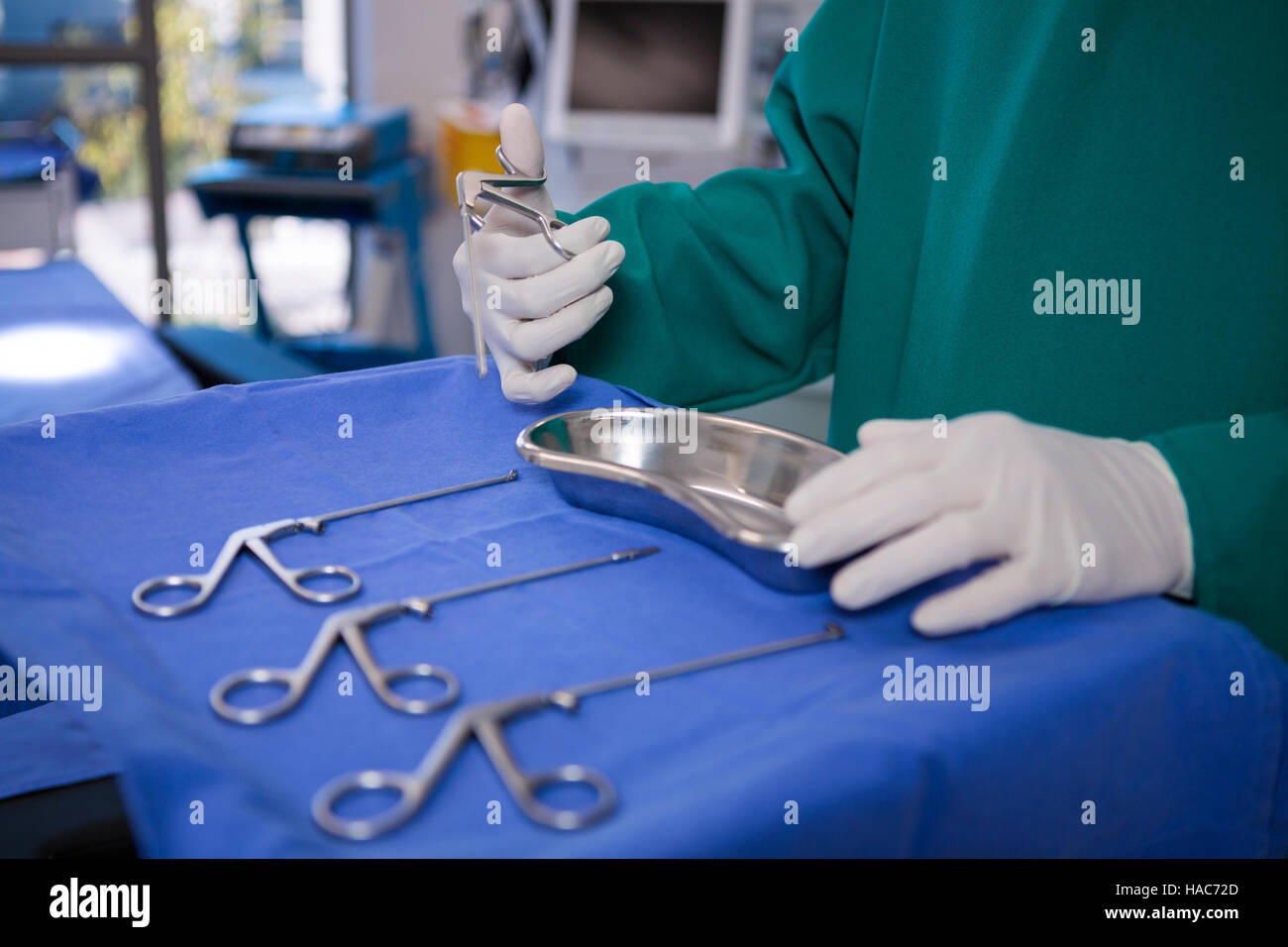 Mid section of surgeon holding surgical tool in operation theater Stock ...