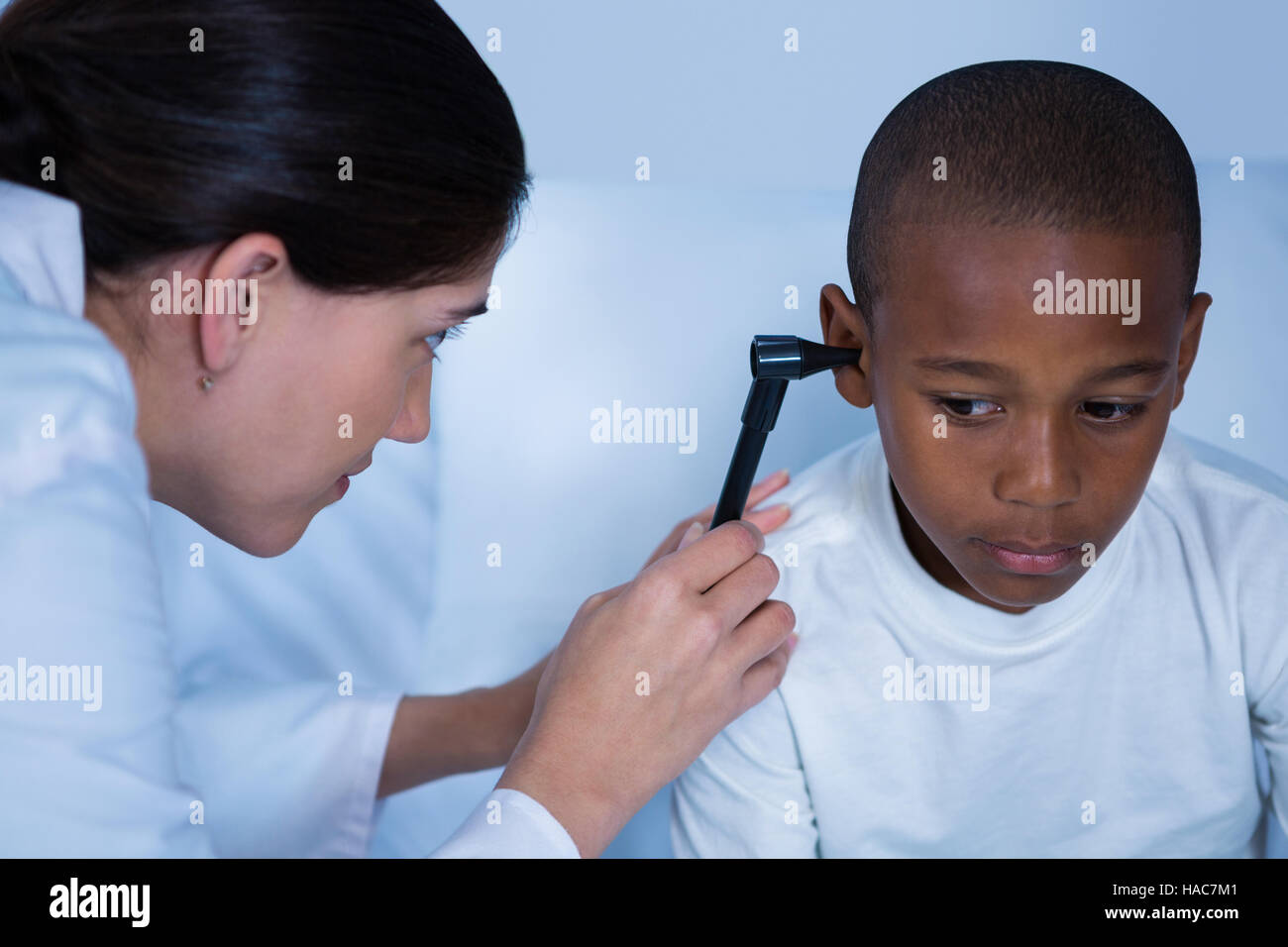 Female doctor examining patient ear with otoscope Stock Photo - Alamy