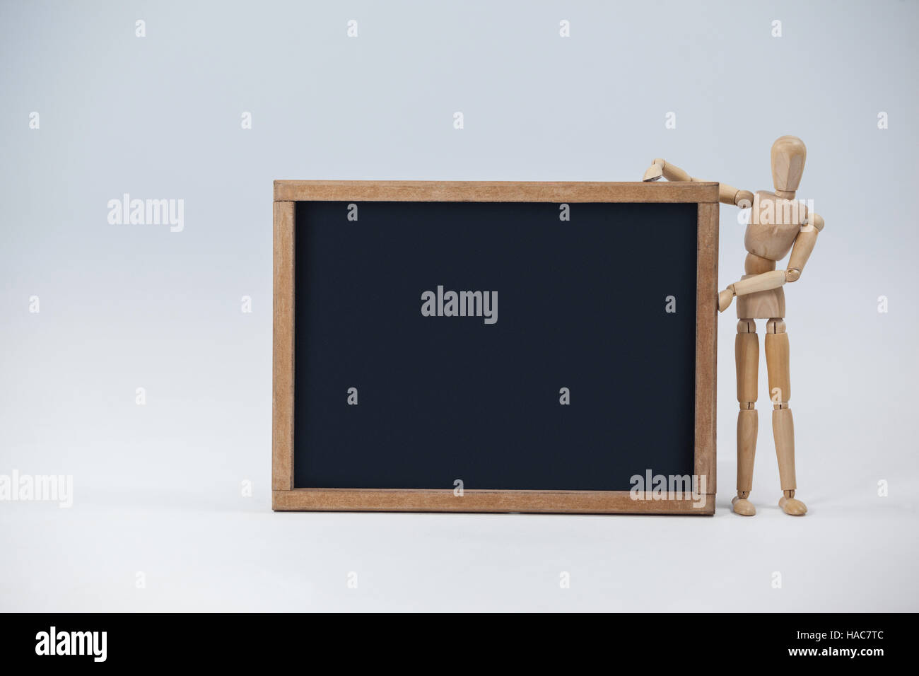 Wooden figurine standing beside a slate board Stock Photo - Alamy