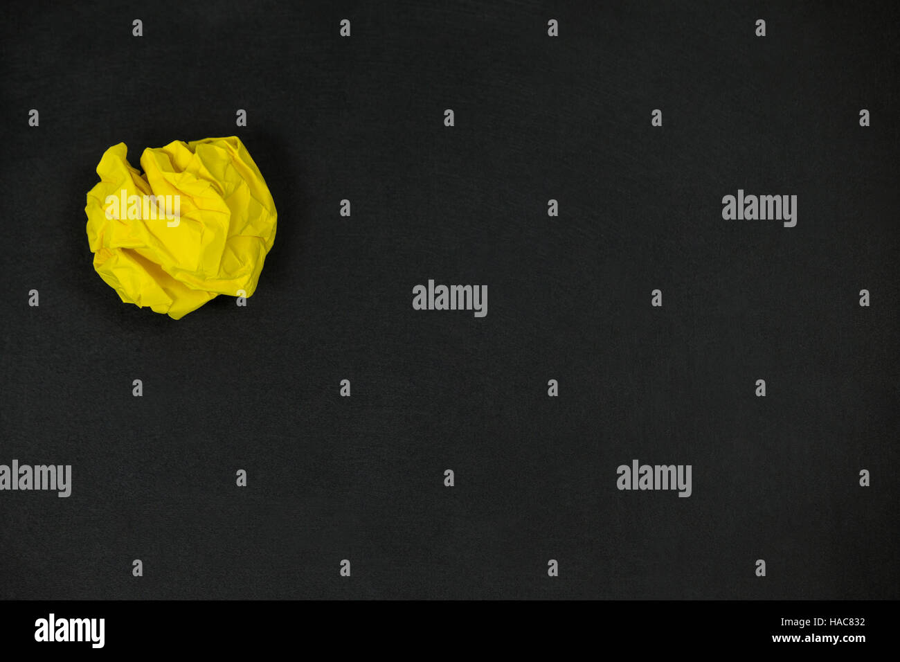 Yellow crumpled paper ball on a black background Stock Photo - Alamy