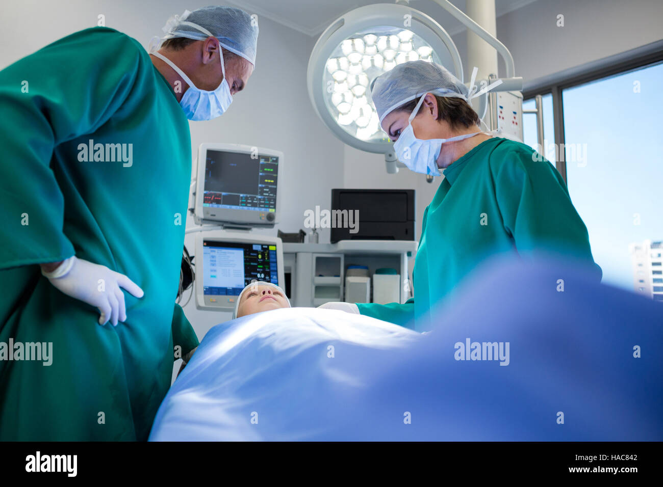 Surgeons interacting with patient in operation theater Stock Photo - Alamy