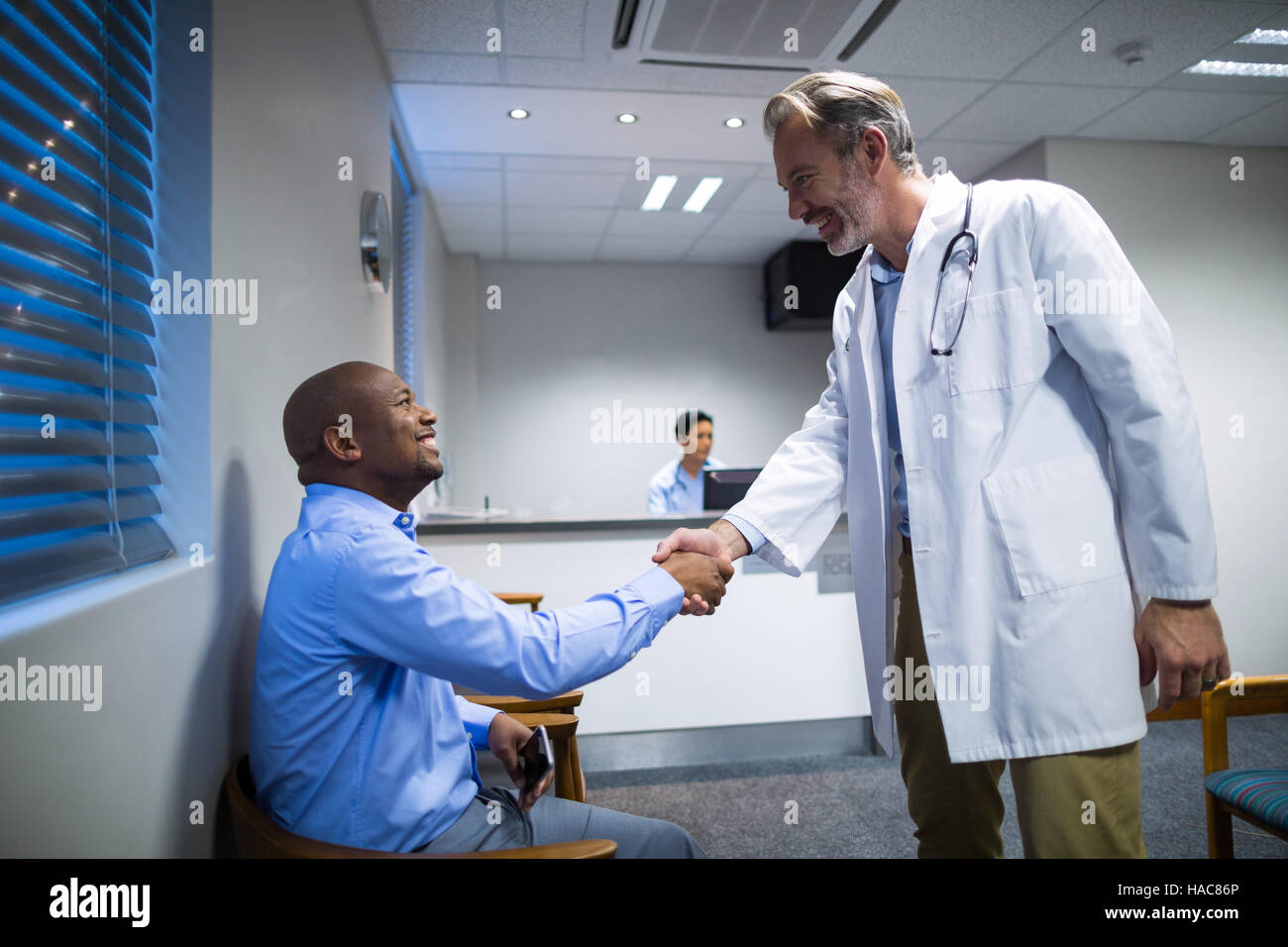 Male doctor shaking hands with patient Stock Photo - Alamy
