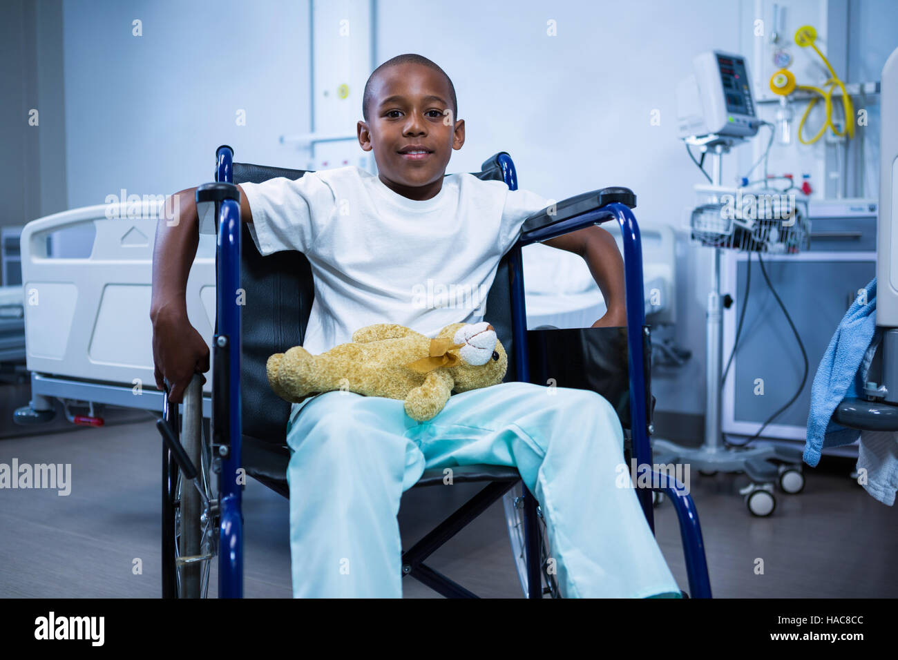 Portrait of boy sitting on wheelchair with teddy bear in ward Stock ...