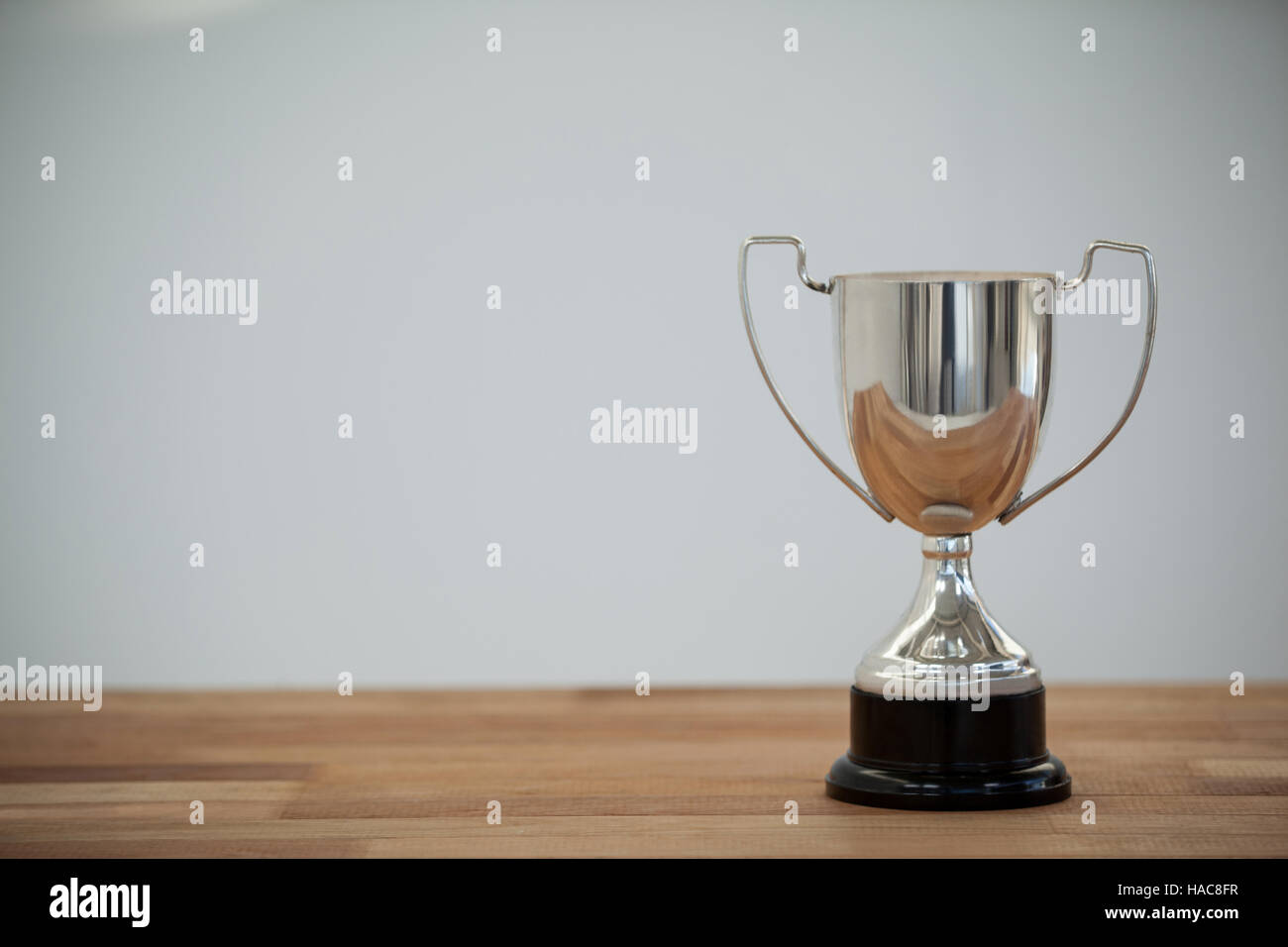 Silver trophy on wooden table Stock Photo - Alamy
