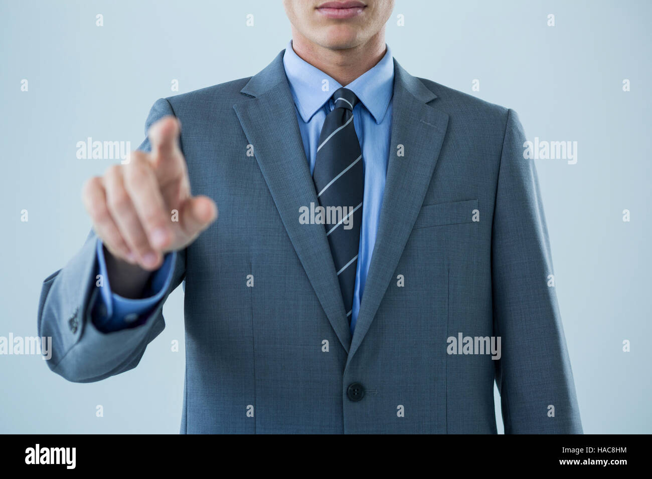 Mid section of businessman touching an invisible screen Stock Photo - Alamy