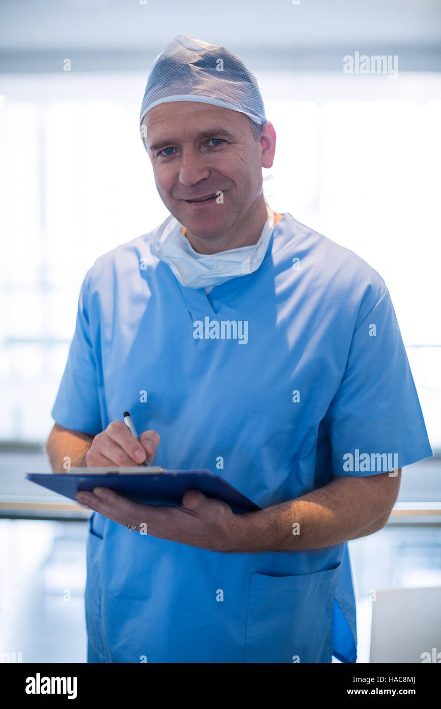 Male surgeon writing on a clipboard Stock Photo - Alamy