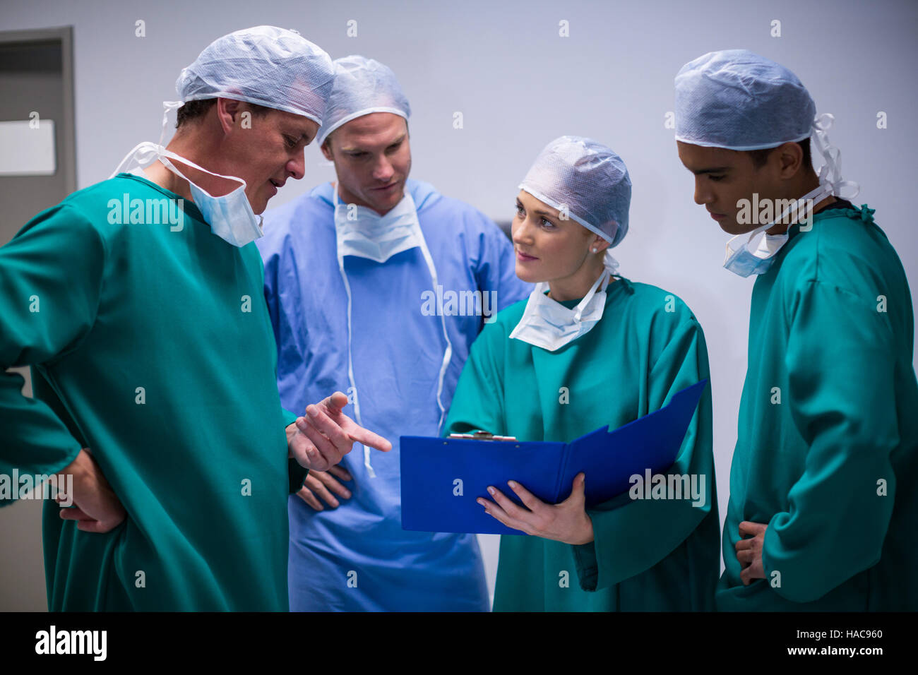 Surgeons having discussion on file in corridor Stock Photo - Alamy