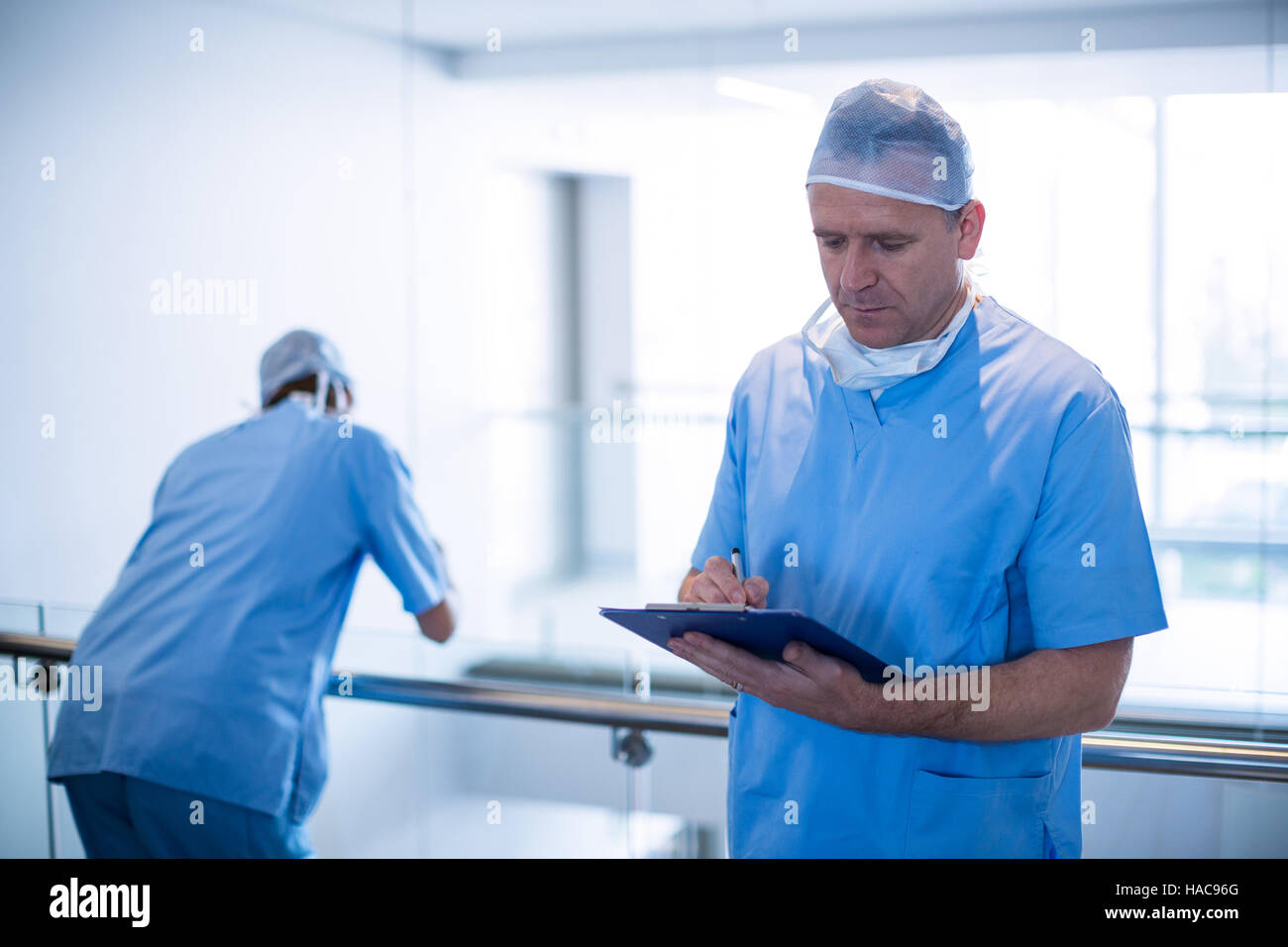 Male surgeon writing on a clipboard Stock Photo - Alamy