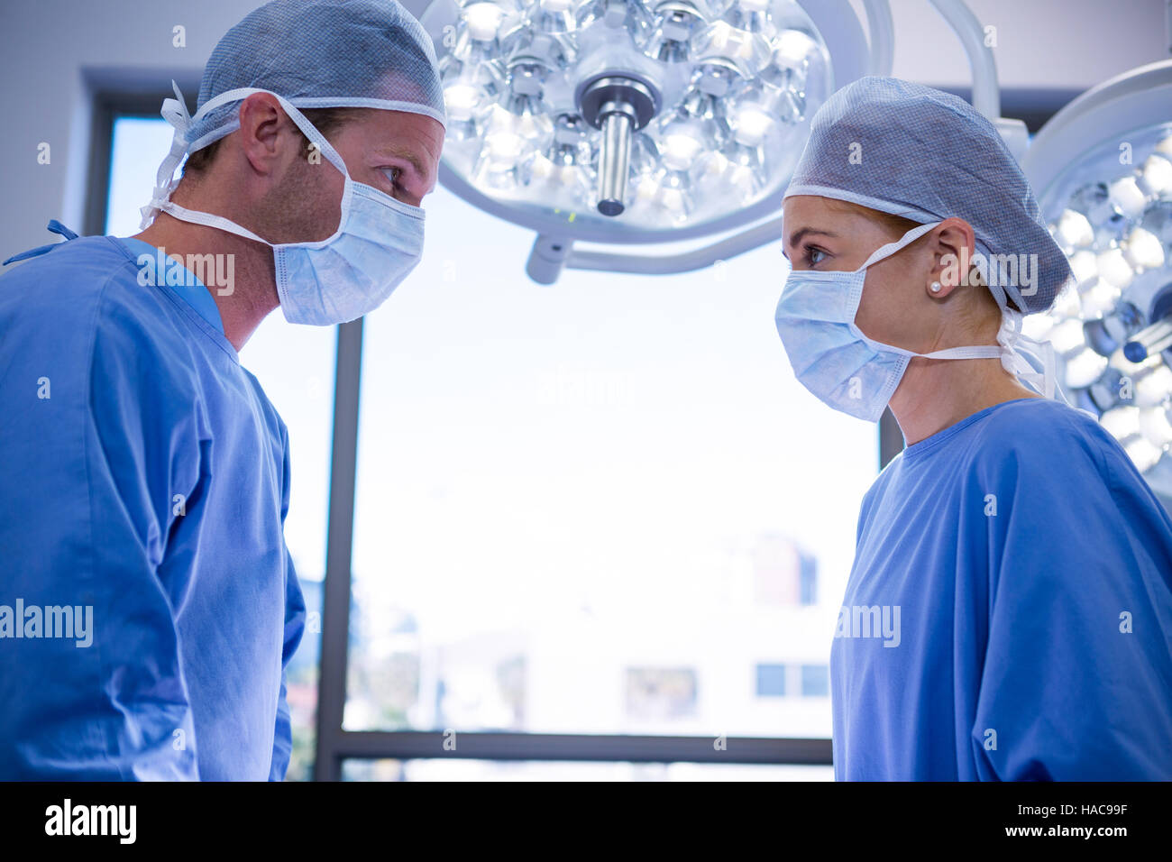 Surgeons interacting with each other in operation theater Stock Photo ...