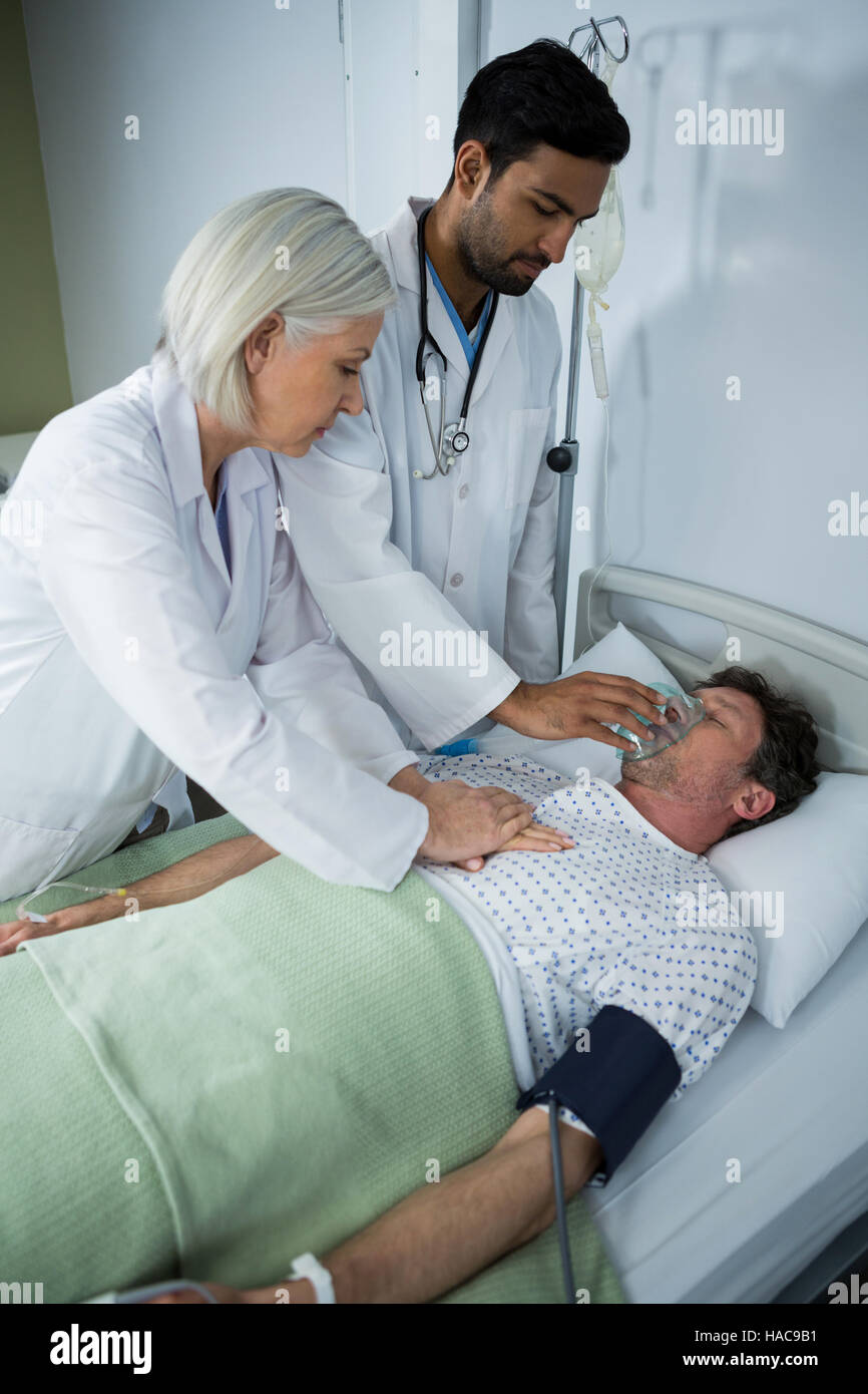 Doctor placing an oxygen mask on the face of a patient Stock Photo - Alamy