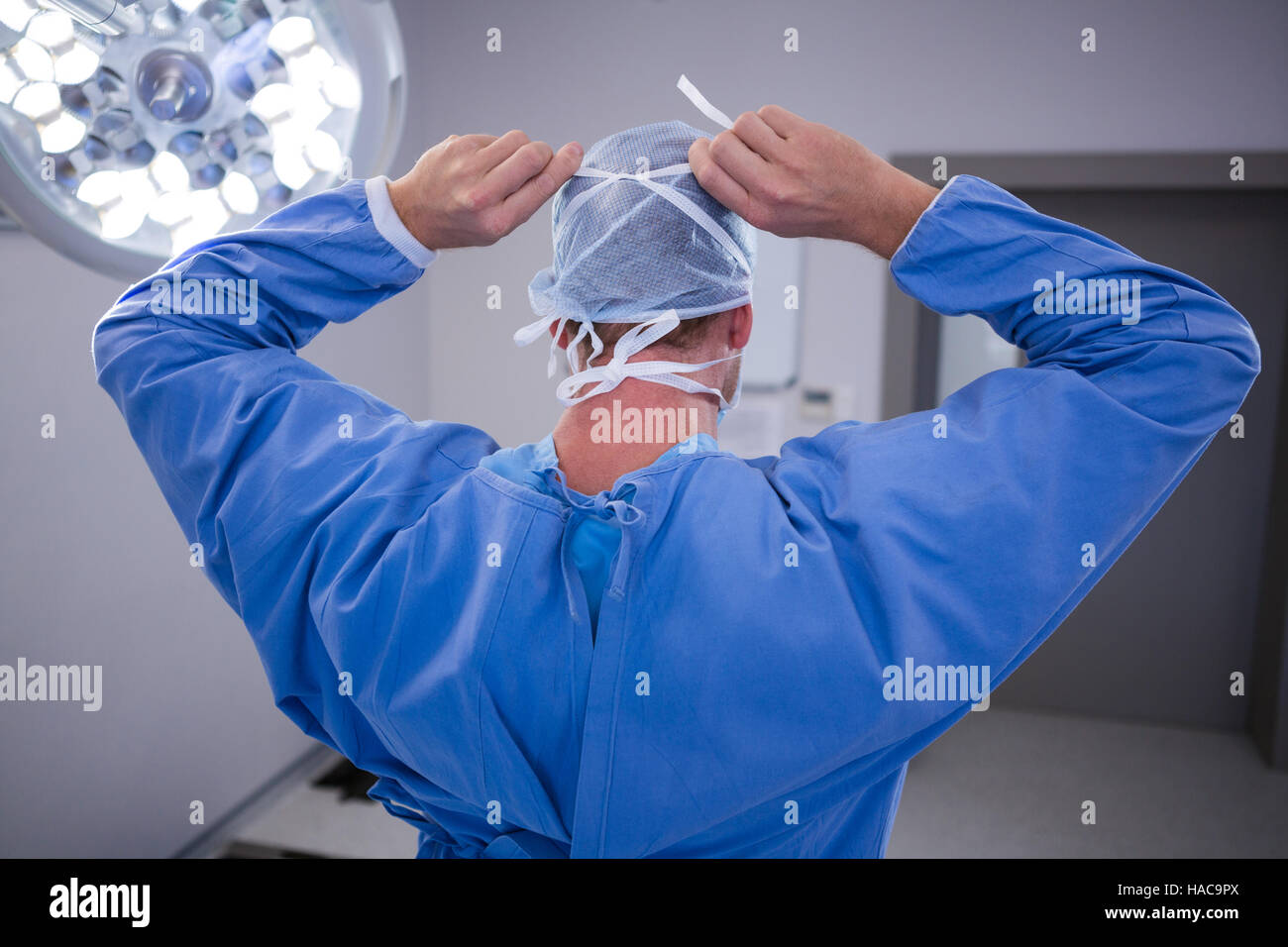 Surgeon tying surgical mask in operation room Stock Photo - Alamy