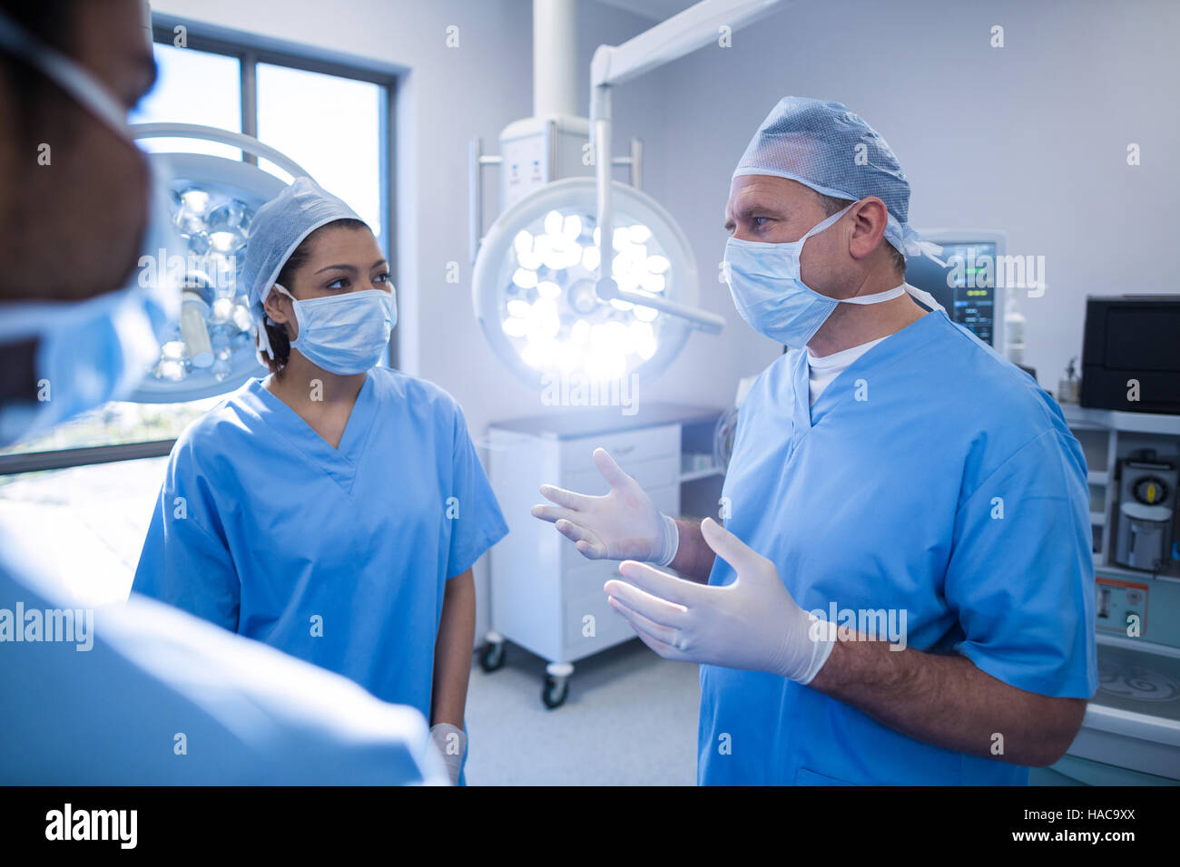 Group of surgeons interacting with each other in operation room Stock ...