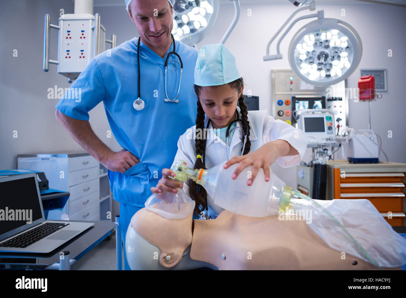 Doctor assisting a girl in placing a oxygen on dummy Stock Photo - Alamy