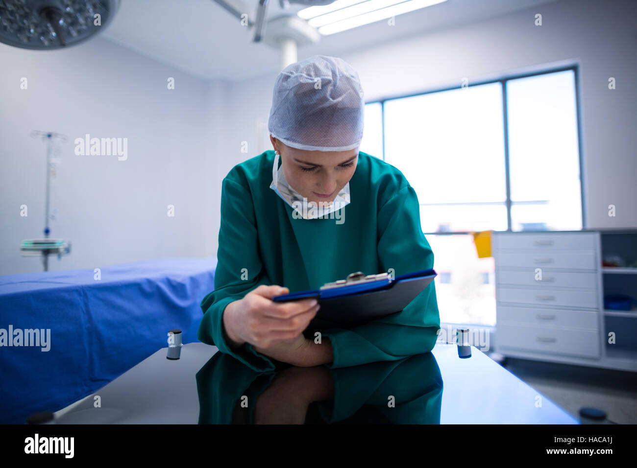 Female surgeon reading reports in operation theater Stock Photo - Alamy