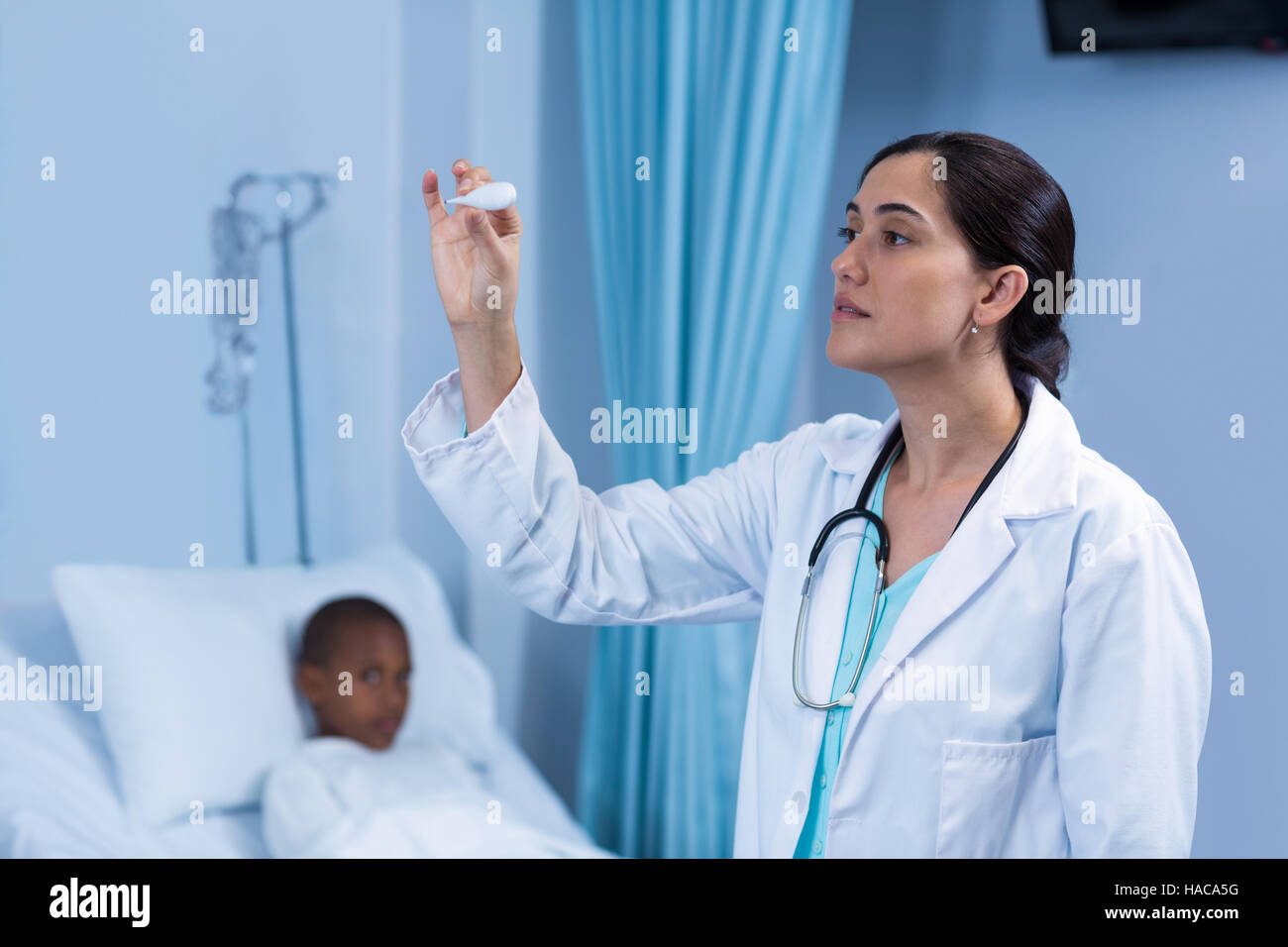 Female doctor checking fever from digital thermometer Stock Photo - Alamy