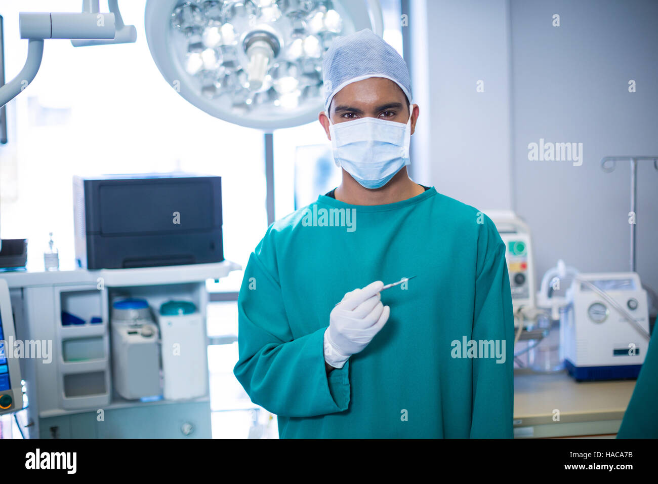 Male surgeon standing with surgical tool in operation theater Stock ...