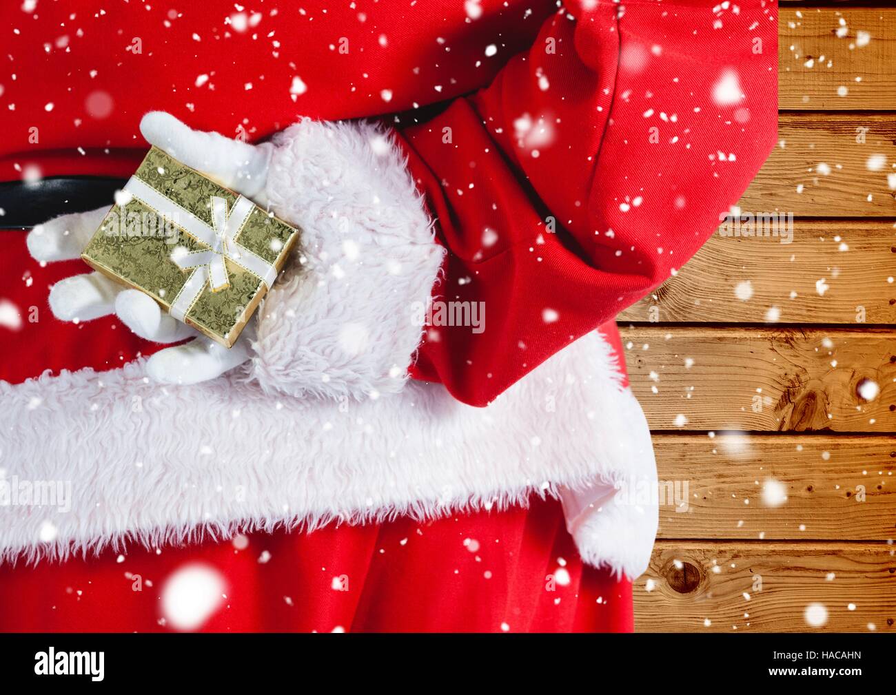 Santa hiding christmas gift behind his back Stock Photo - Alamy