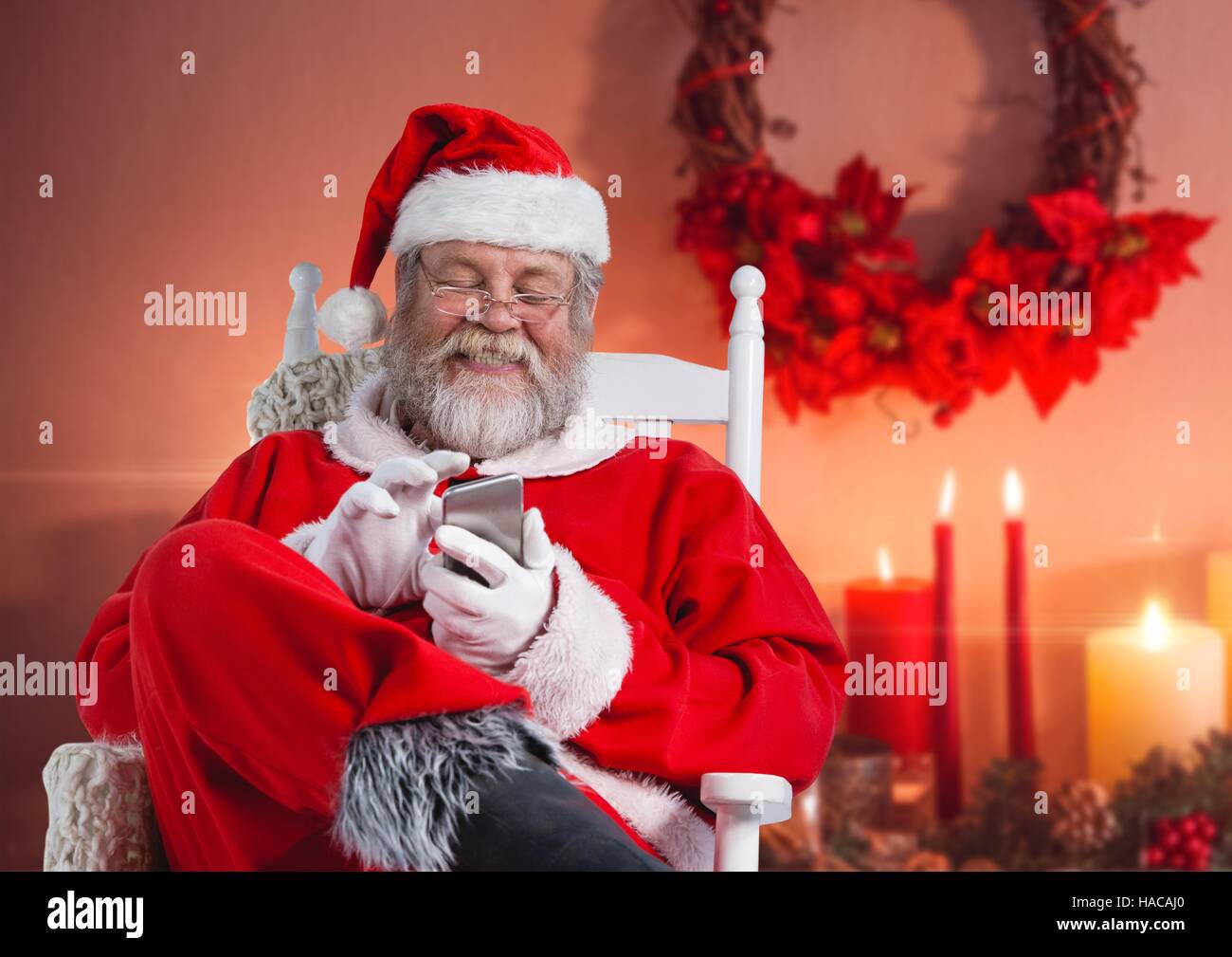 Happy santa sitting on chair and using mobile phone Stock Photo - Alamy