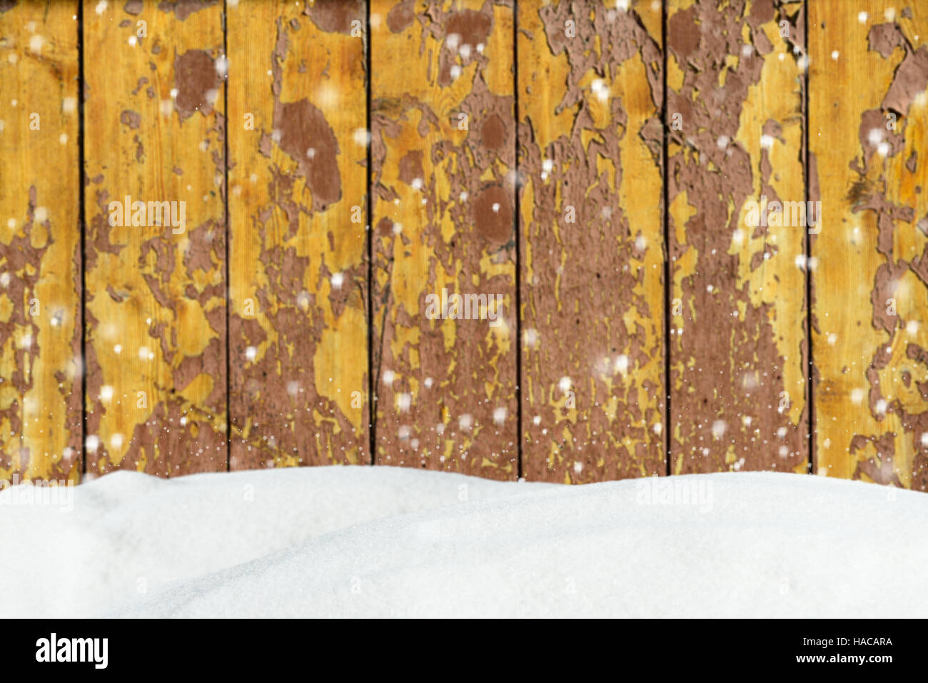 Winter background with snowfall on the old wooden barn wall and ...
