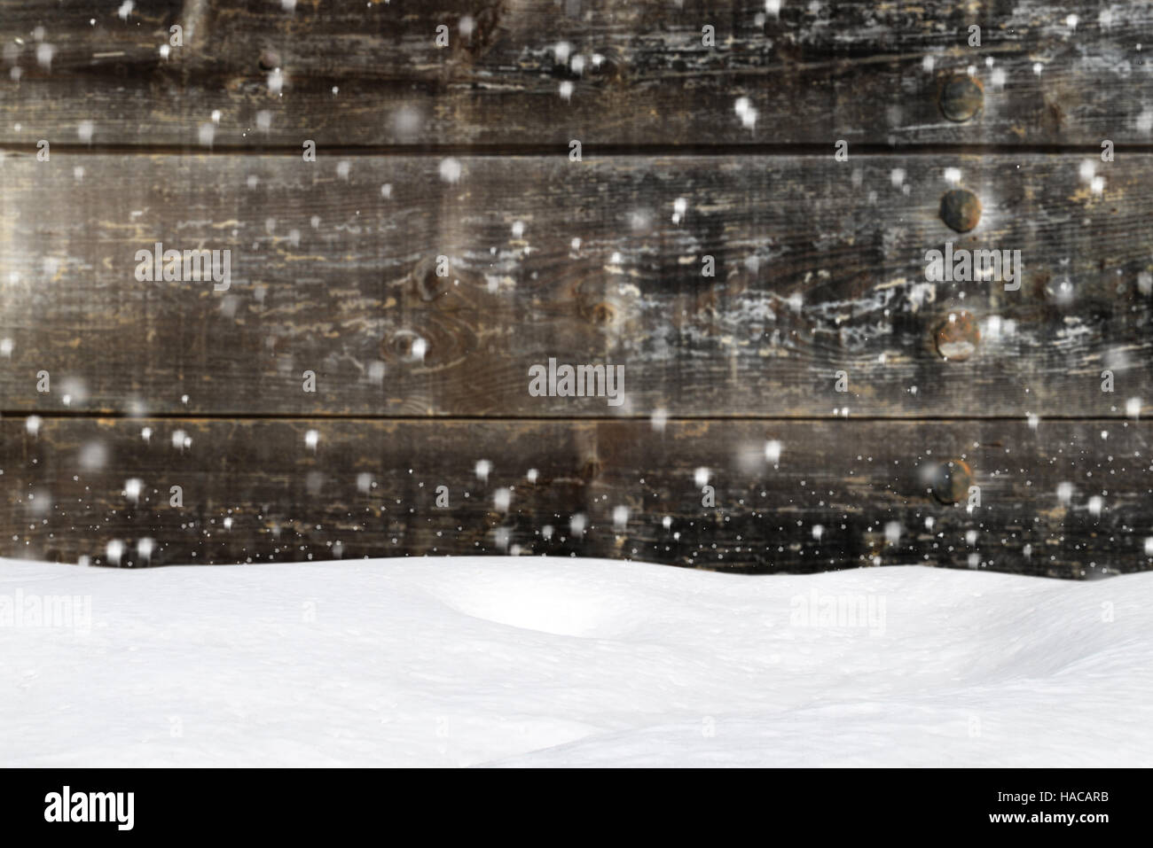 Winter background with snowfall on the old wooden barn wall and ...