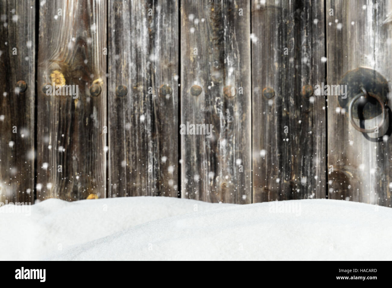 Winter background with snowfall on the old wooden barn wall and ...