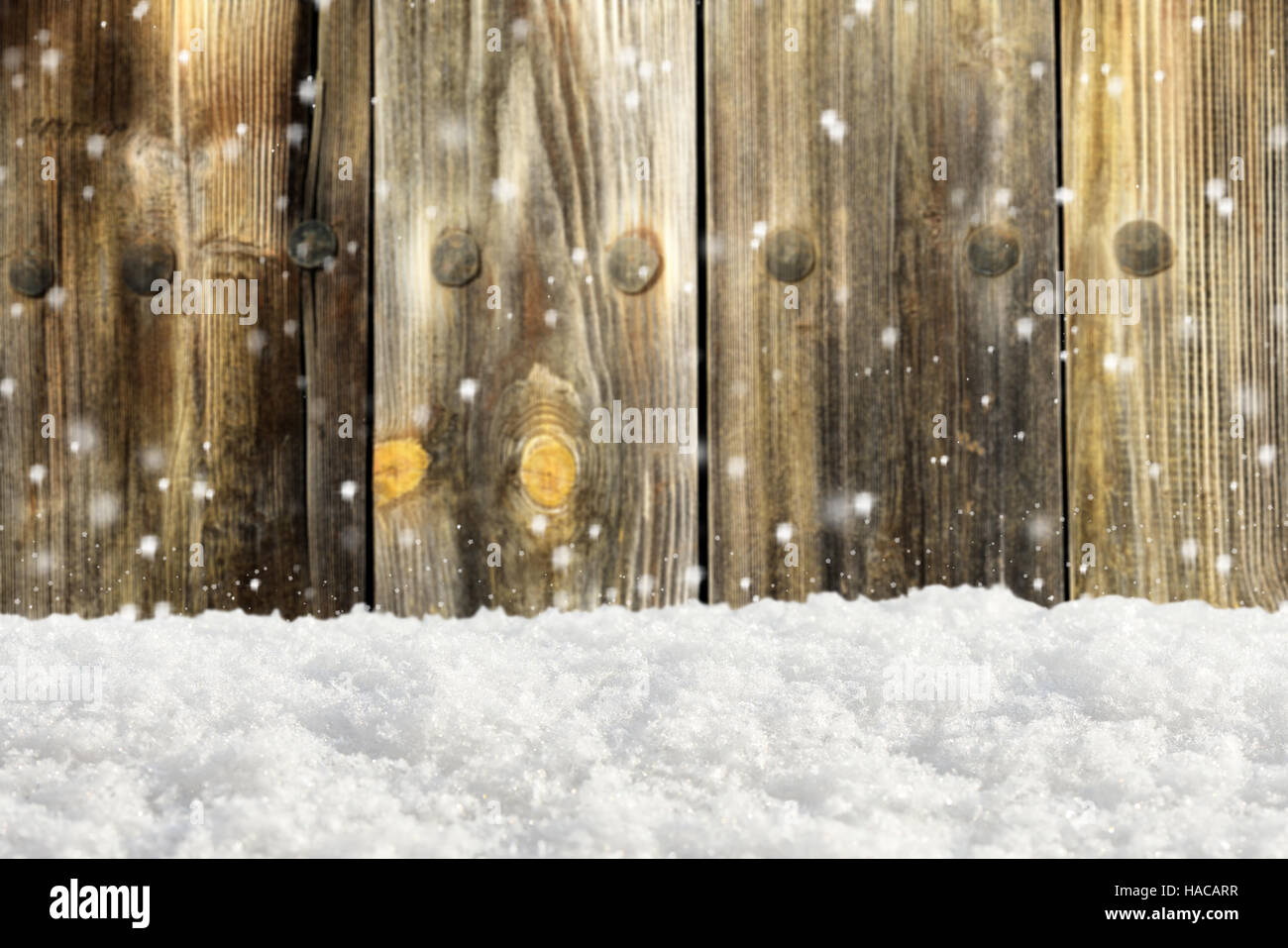Winter background with snowfall on the old wooden barn wall and ...