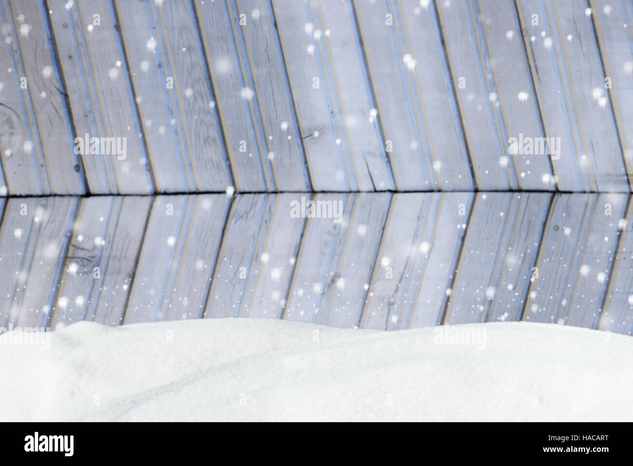 Winter background with snowfall on the old wooden barn wall and ...