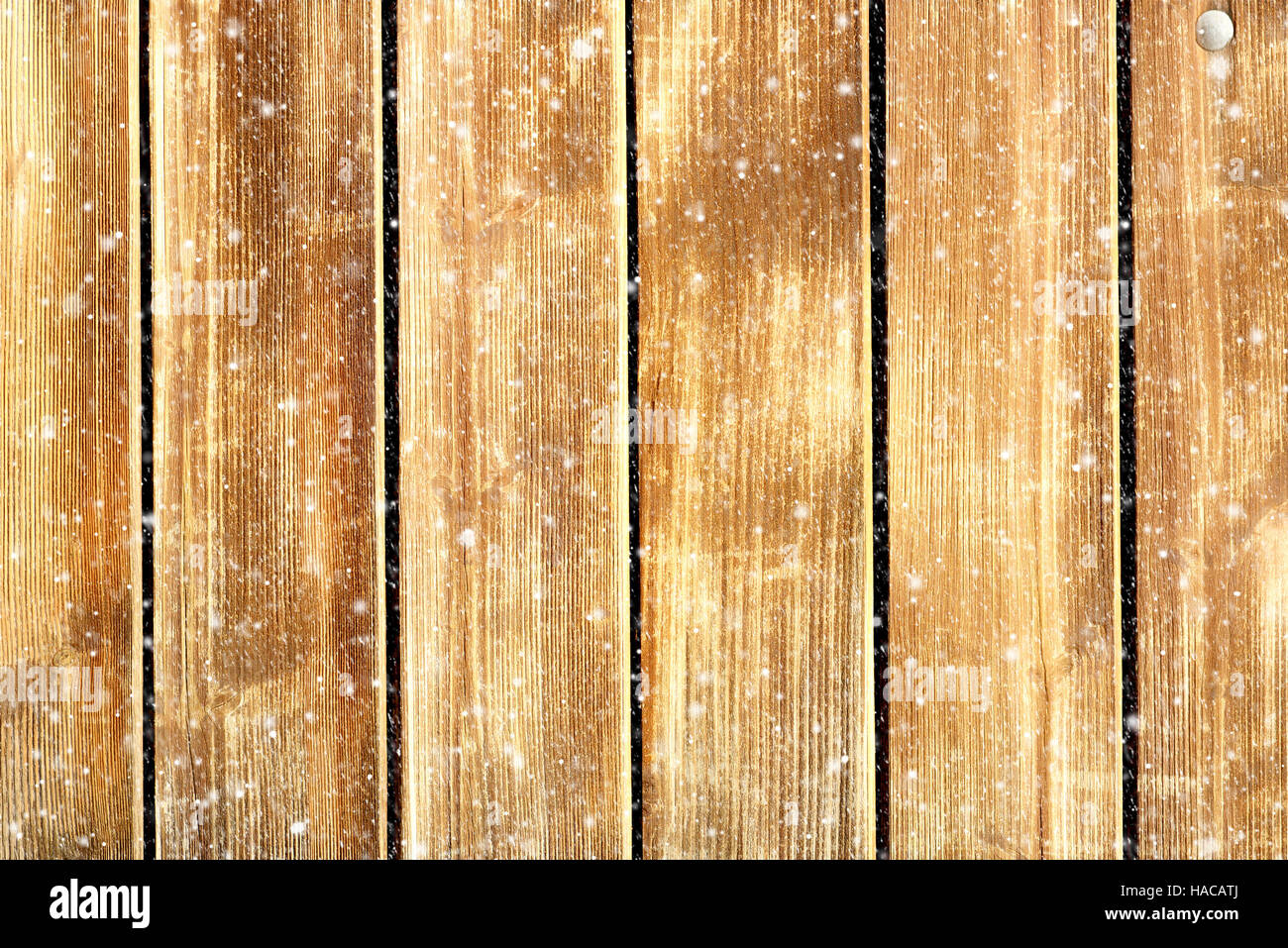 Winter background with snowfall on the old wooden barn wall and ...