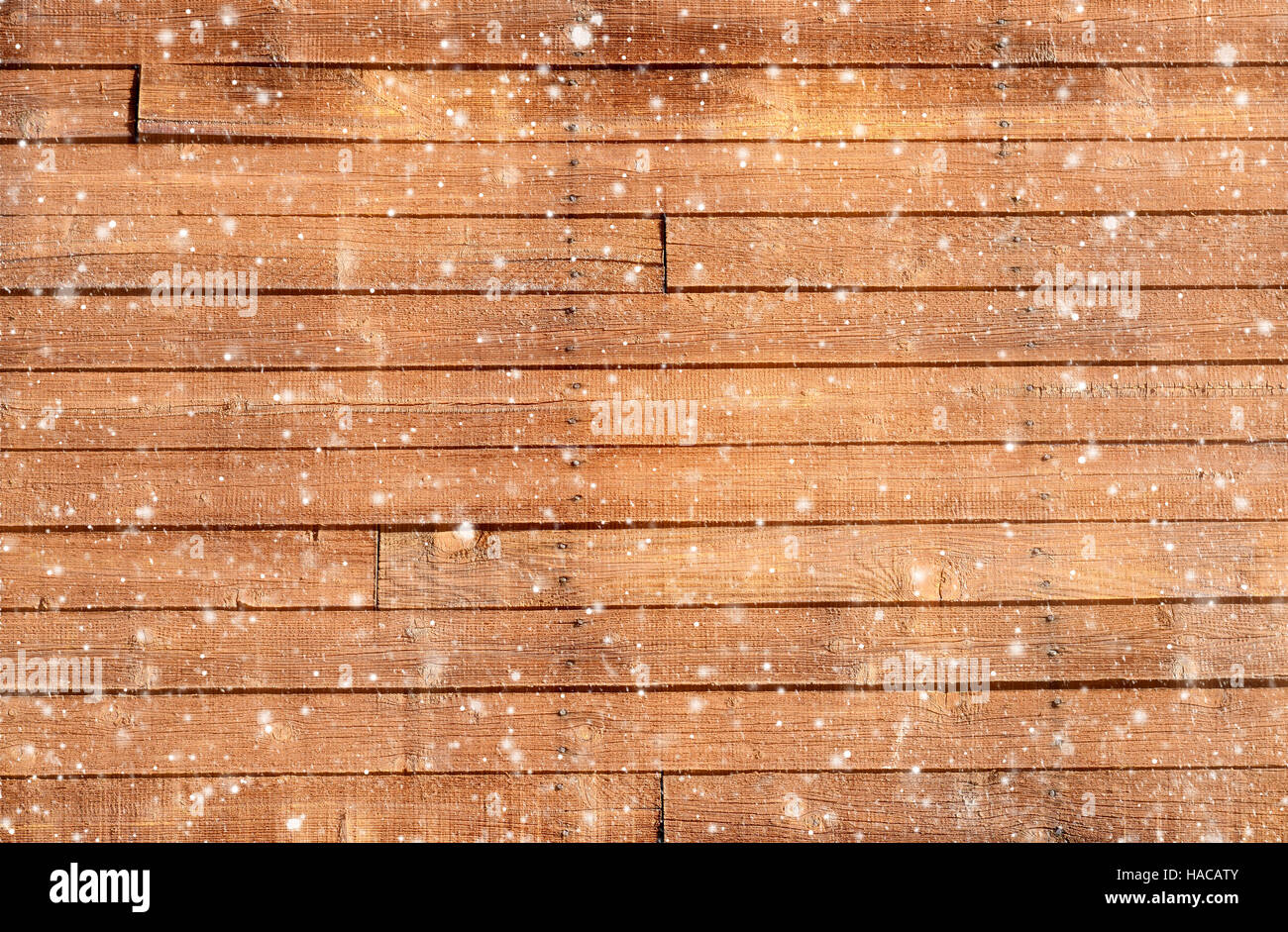 Winter background with snowfall on the old wooden barn wall and ...