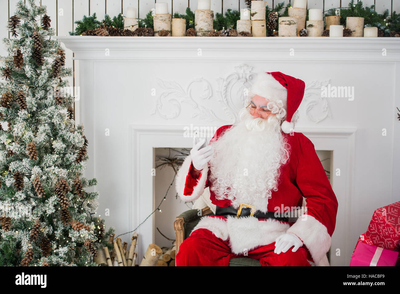 Happy Santa Claus typing a message on the mobile phone and smiling ...